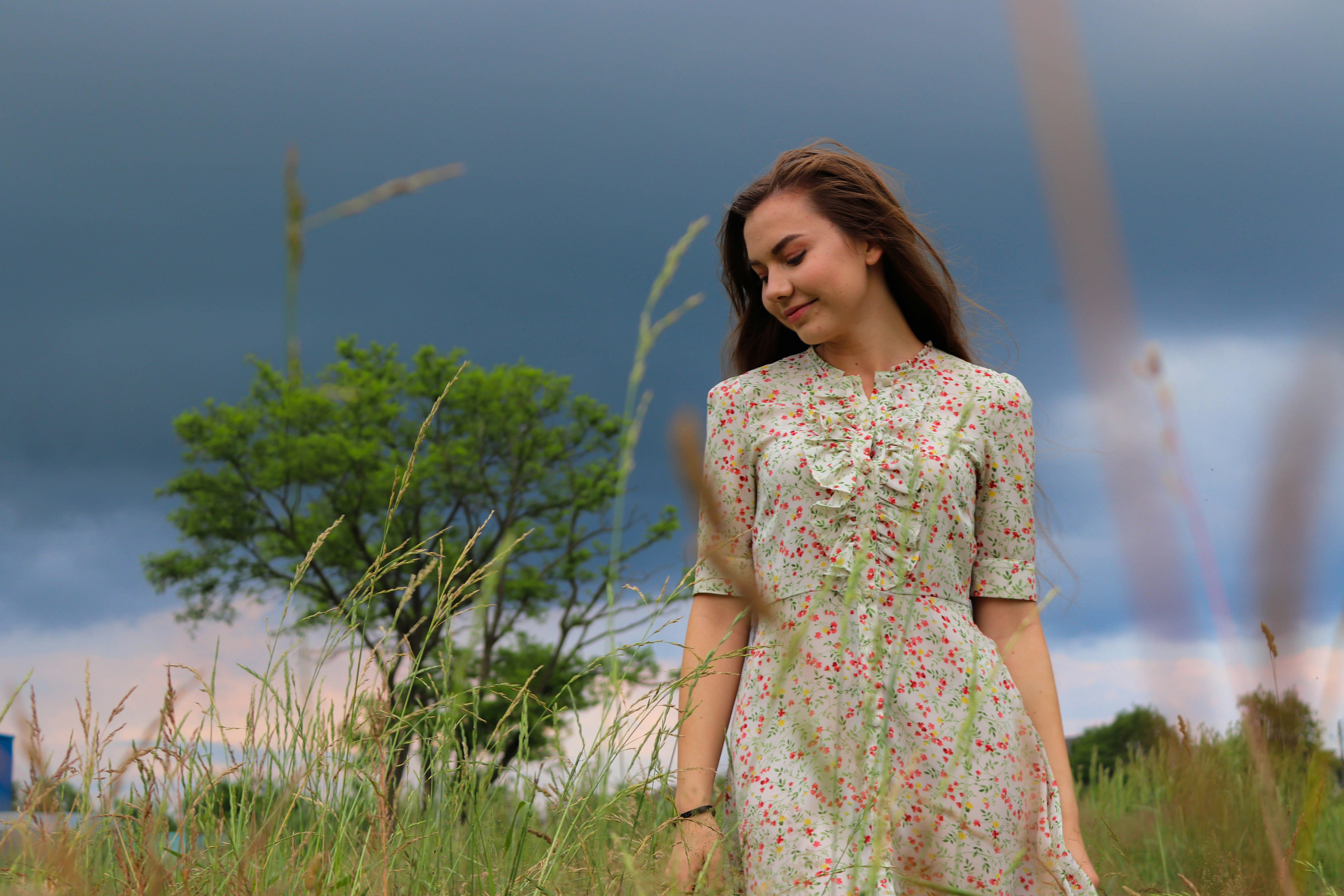 Photo of a girl in a field with a stormy sky