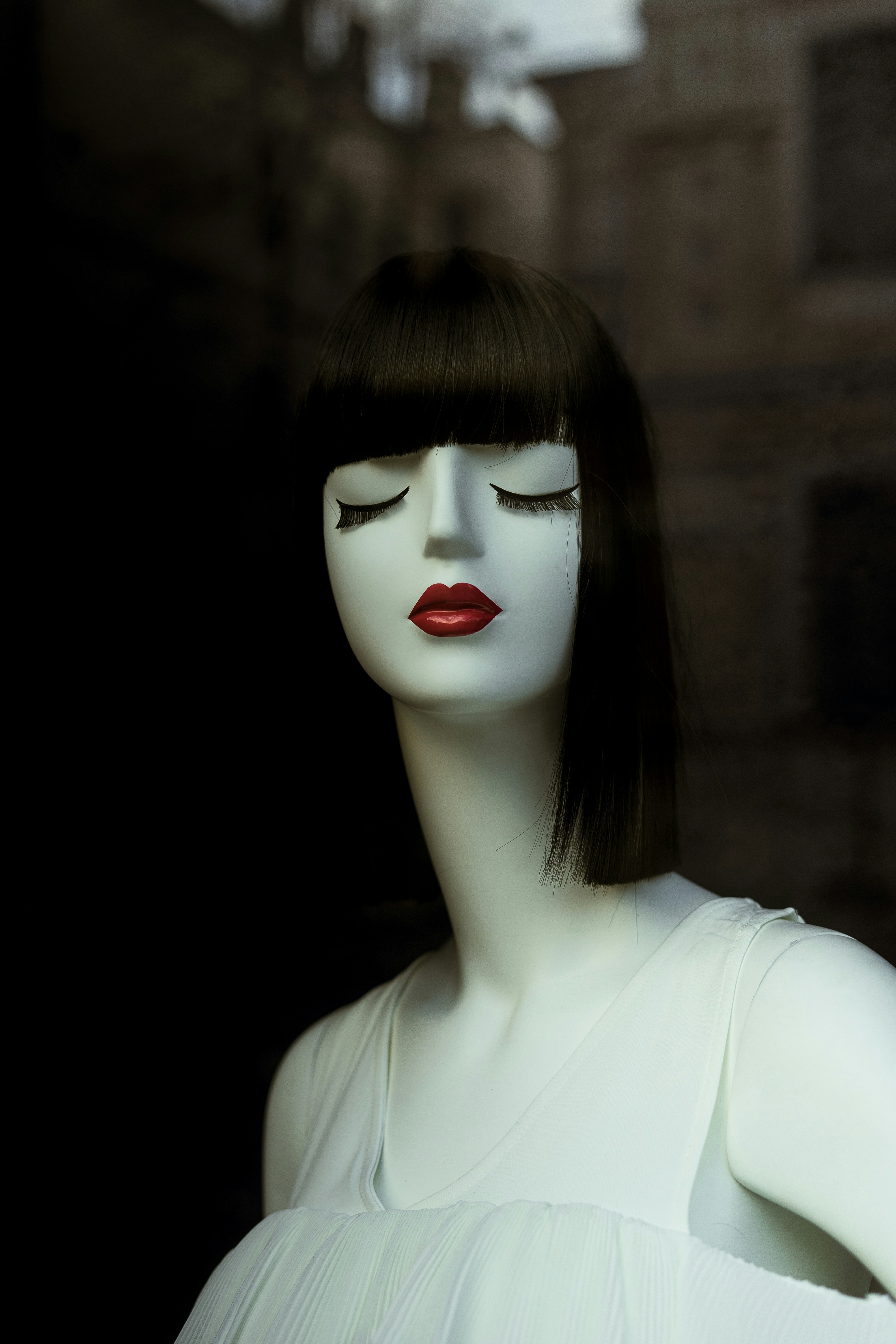 Crimson-Lipped Silence: A Porcelain Portrait Enveloped in Shadow