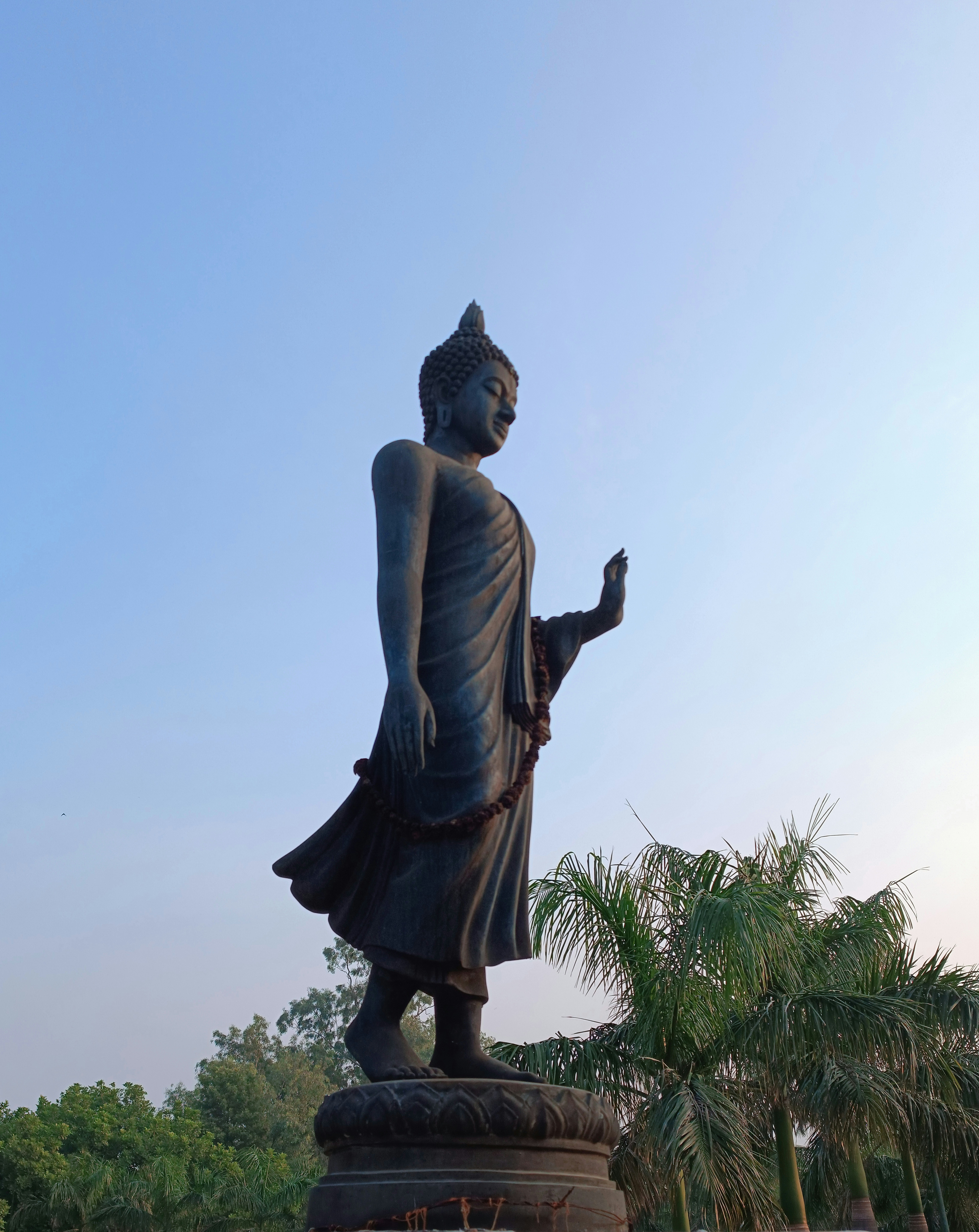 Raised Hand, Open Sky: A Buddha Statue Reaching for Light