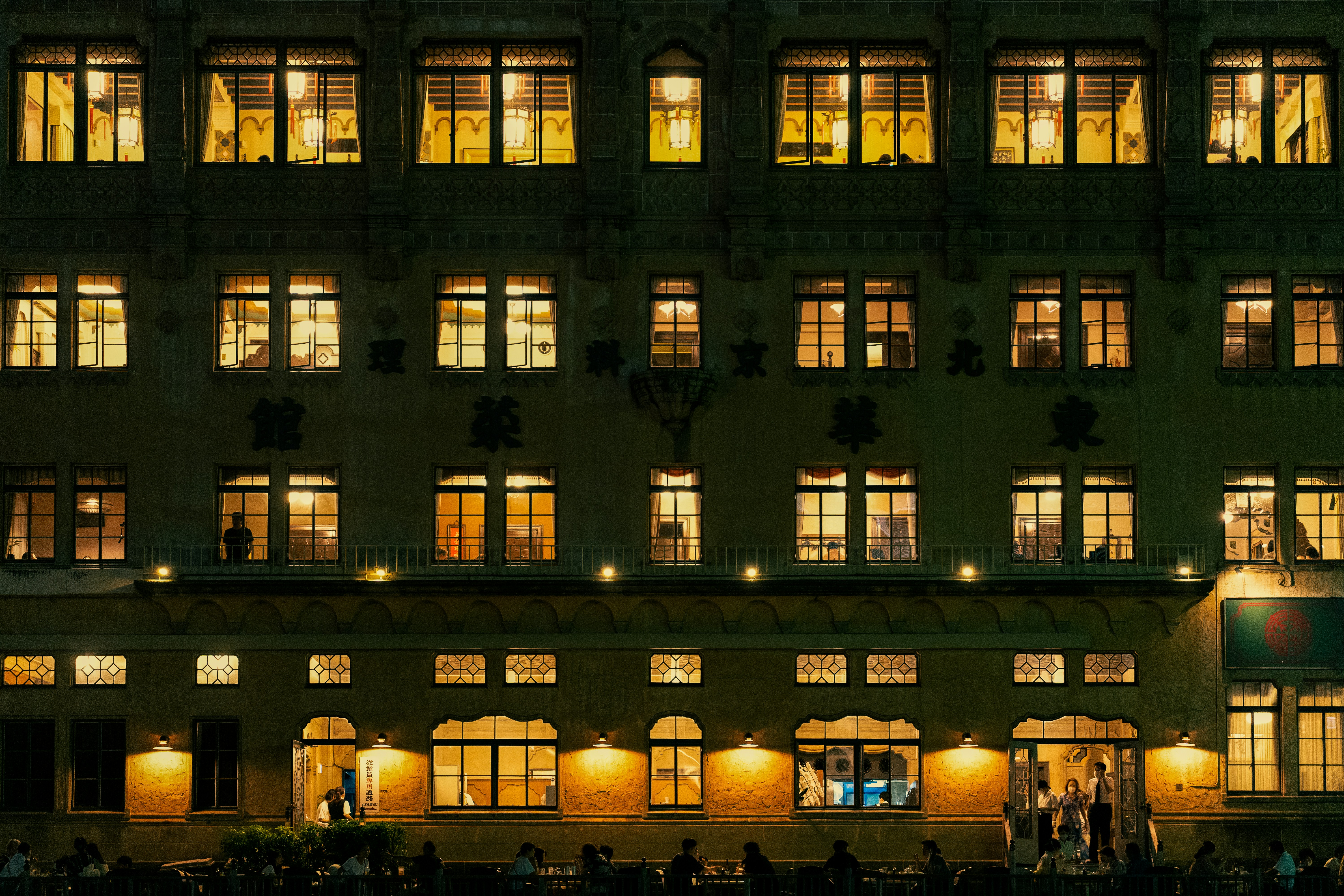 Rows of Warm Windows: Nightfall on a Historic Brick Facade