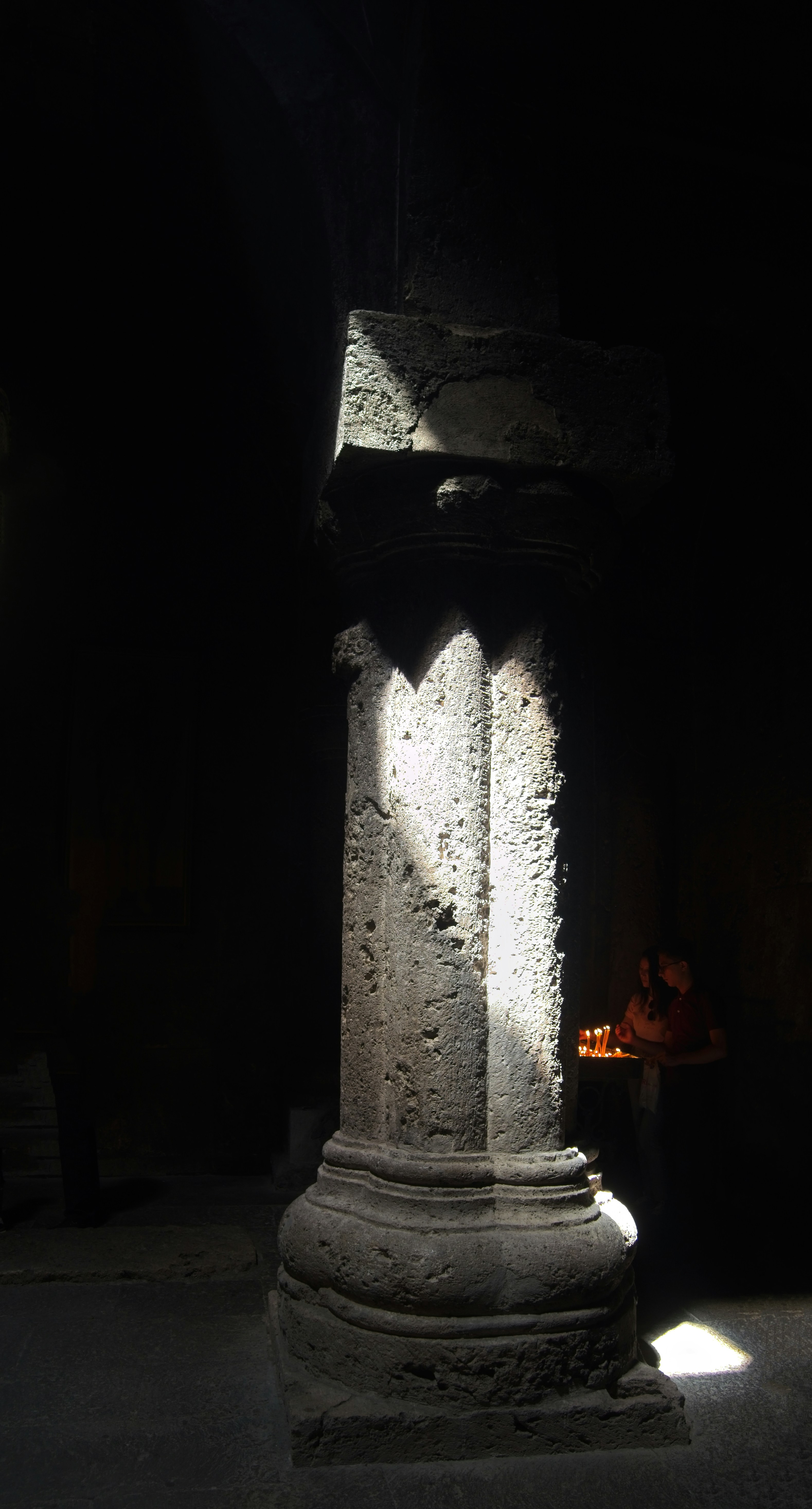A stone pillar with a fire in the background with Dupplin Cross in the ...
