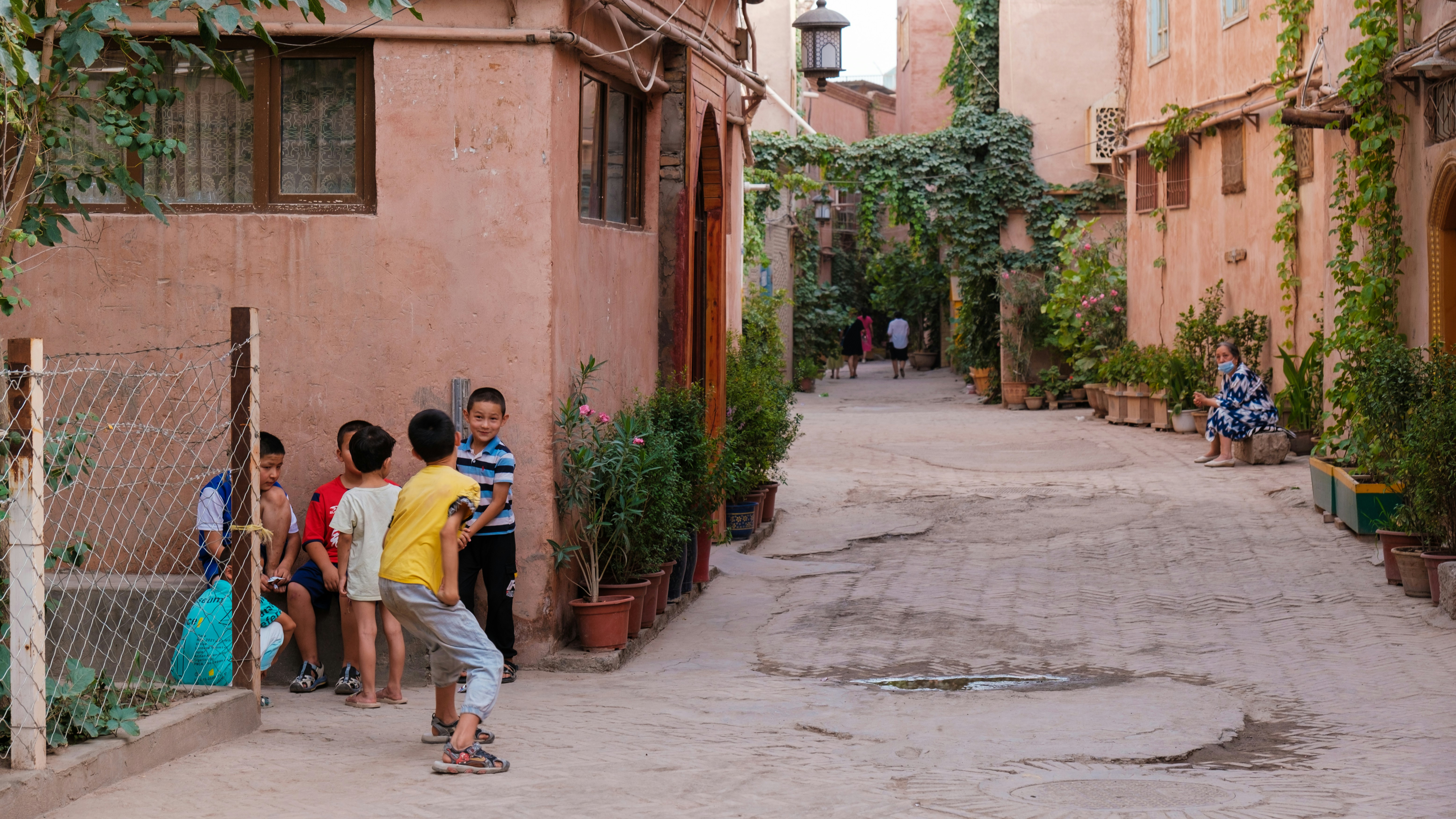 Playful Alleyway Venture: Kids by the Sunlit Courtyard