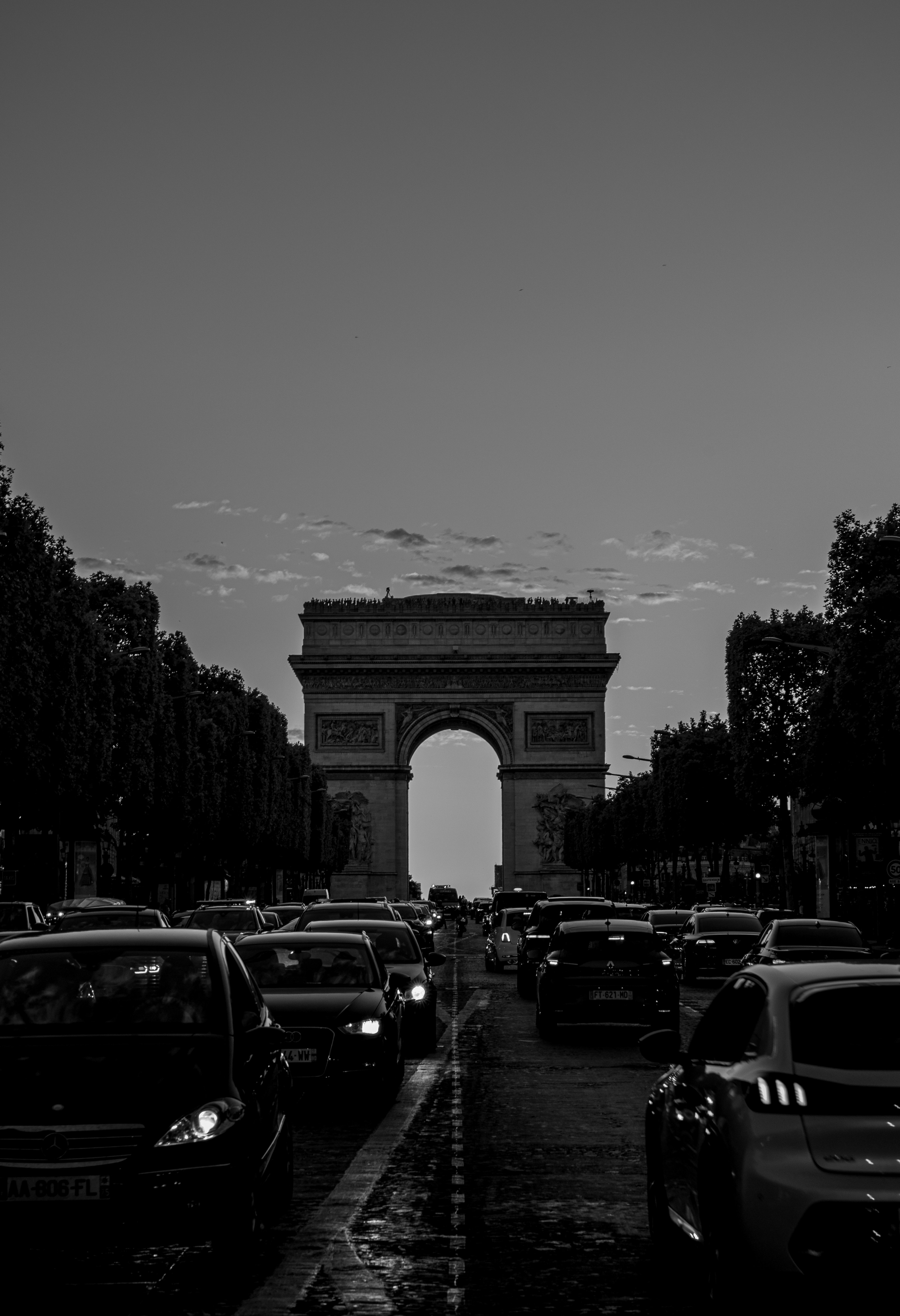 A road with cars on it and a large arch in the background photo – Free ...