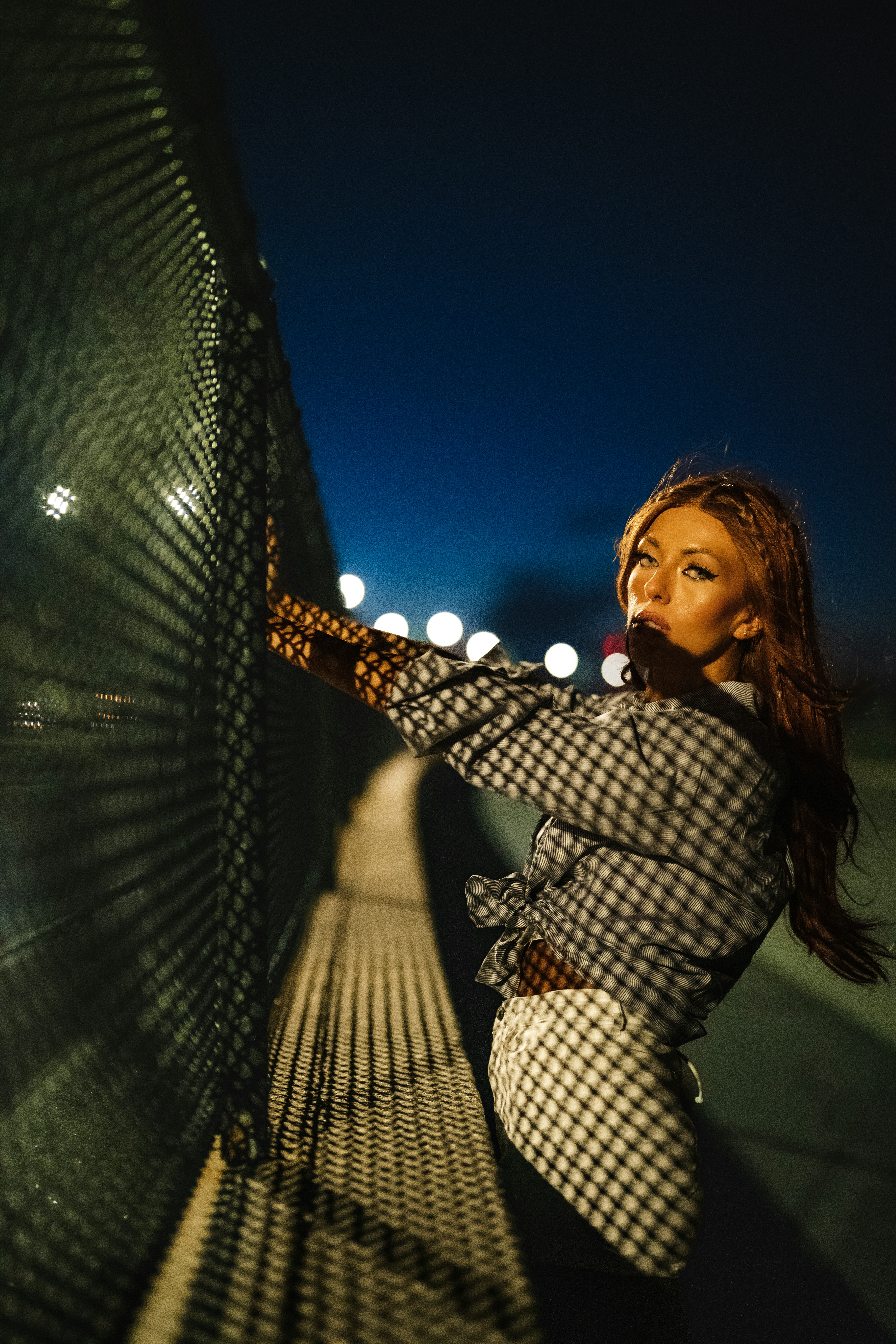 Crossing the Chain-Link Night: Portrait by the Fence