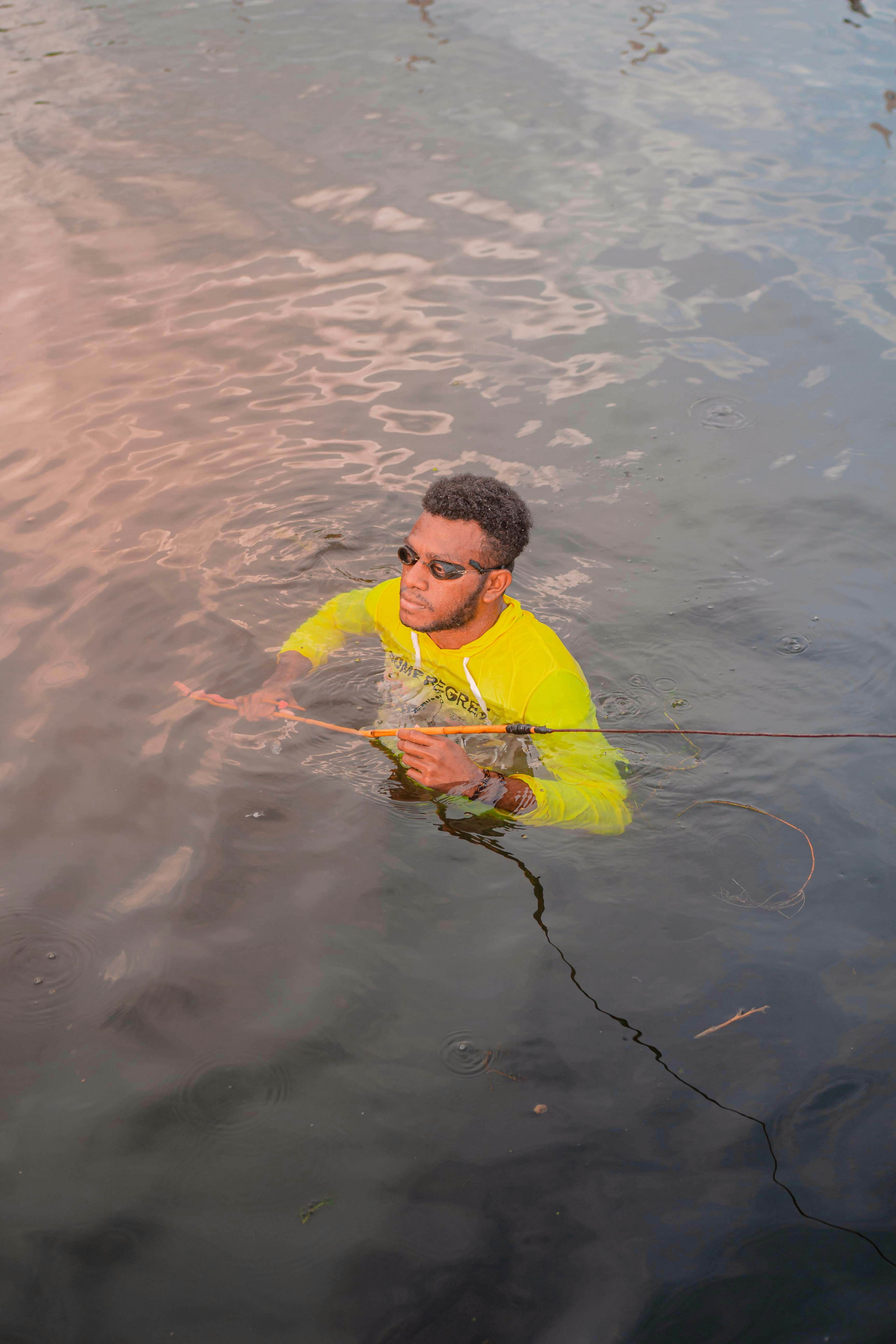 Neon Swimmer in Quiet Water: A Rope-Tethered Moment