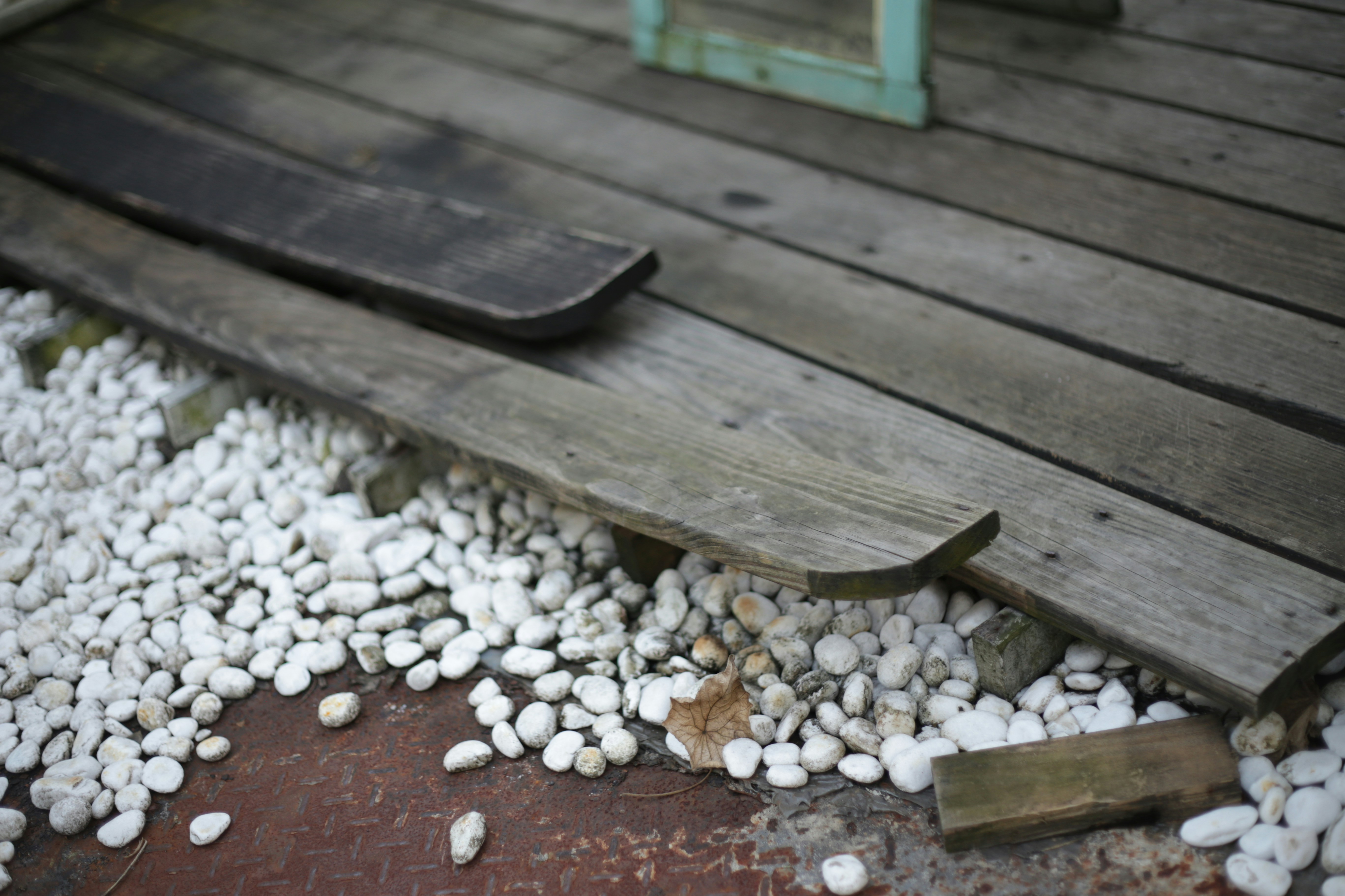 Threshold of Weathered Planks Over a Pebble Border