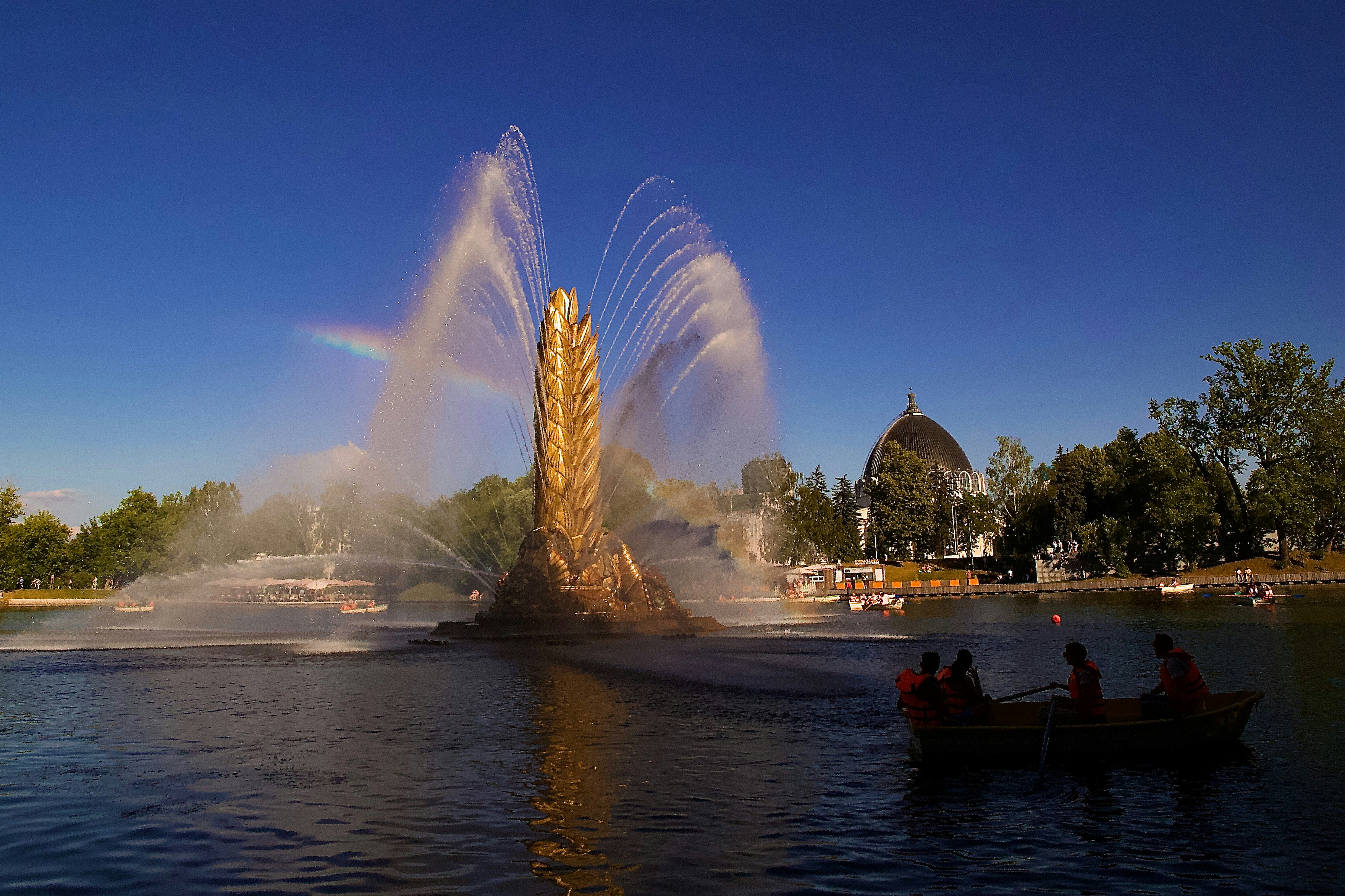 Golden Spire Fountain: Arcing Water over a Riverside Domed Pavilion