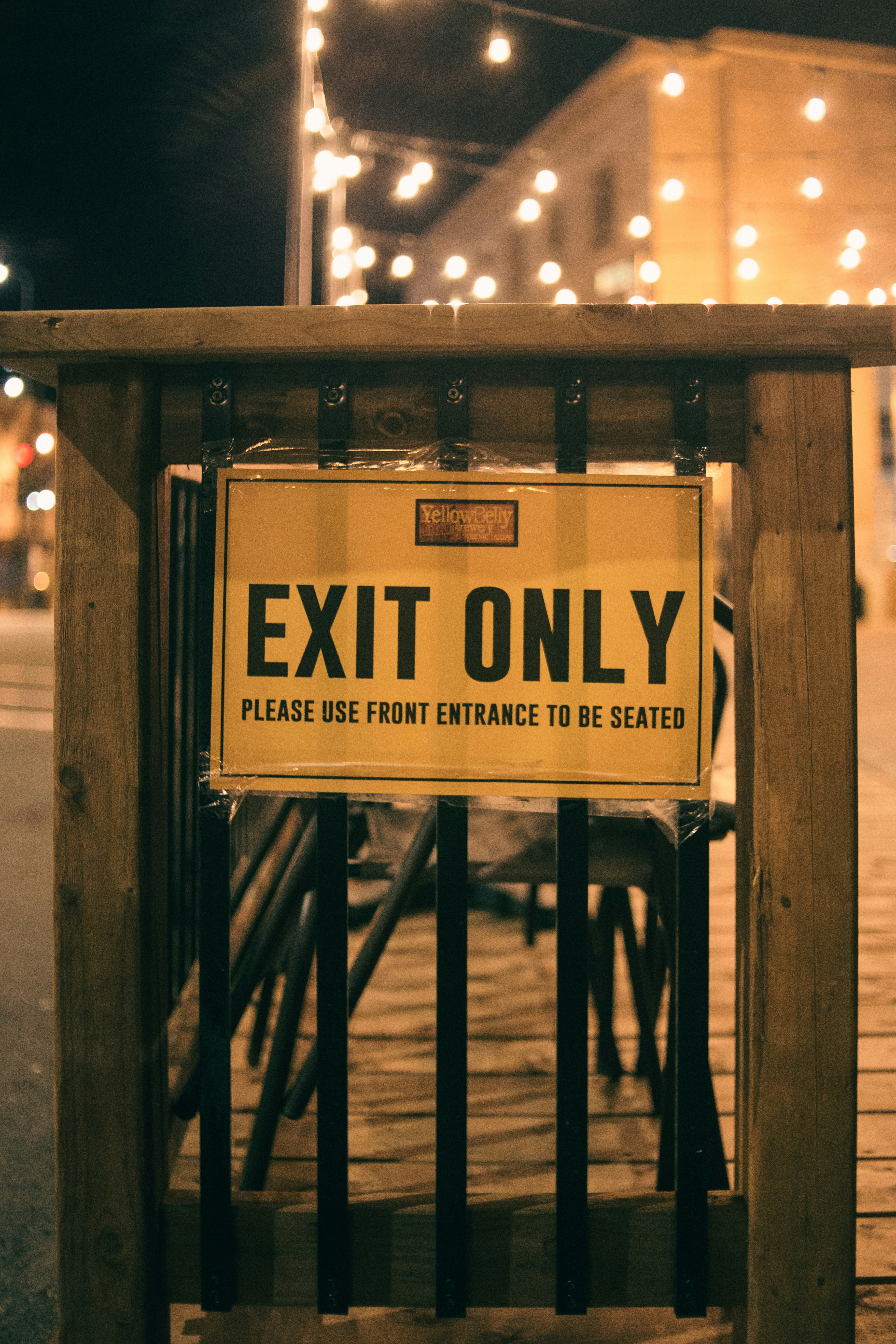Amber Glow Through the Gate: Exit Sign at Night