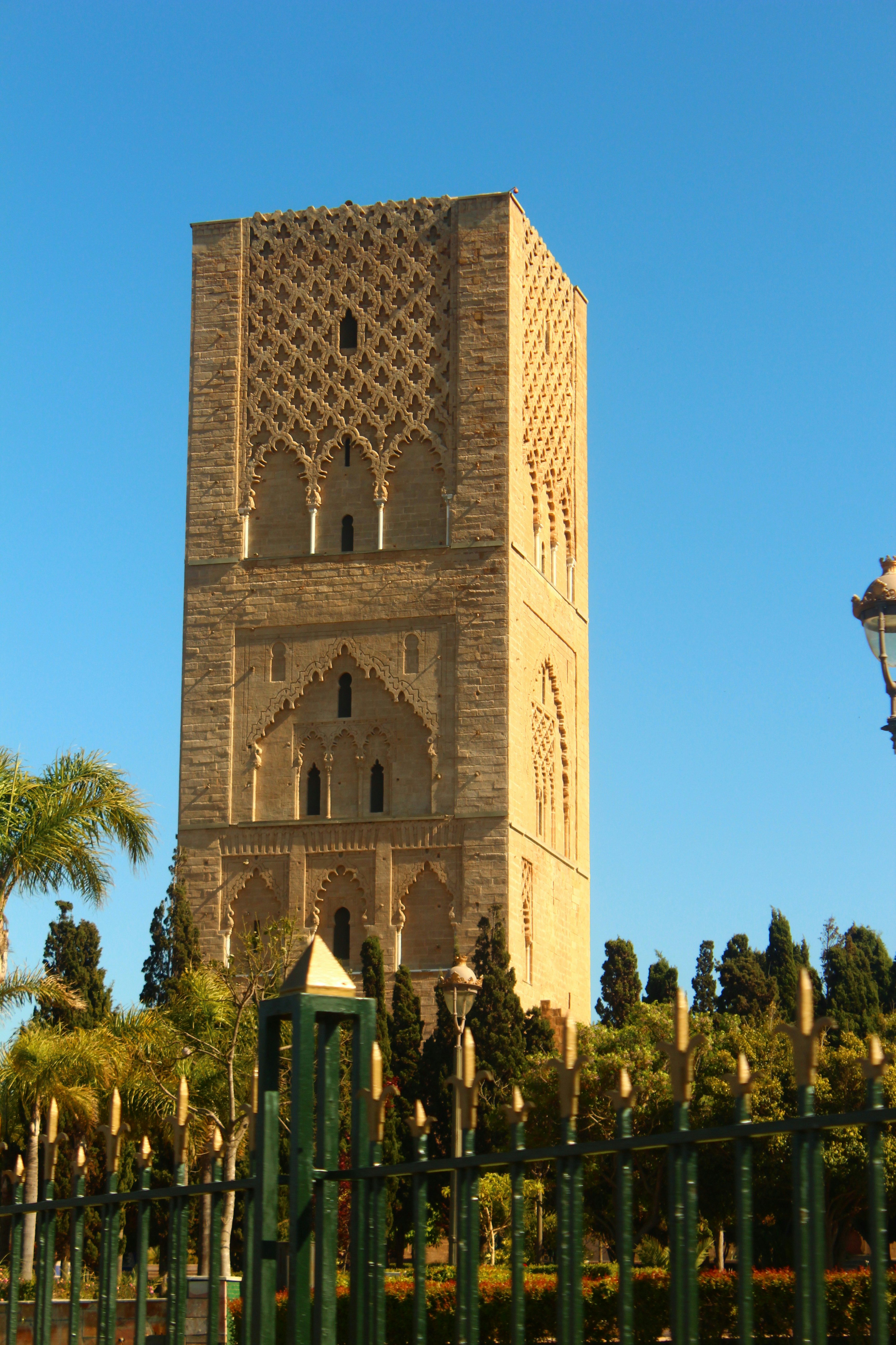 A tall stone building with a fence around it photo – Free Image on Unsplash