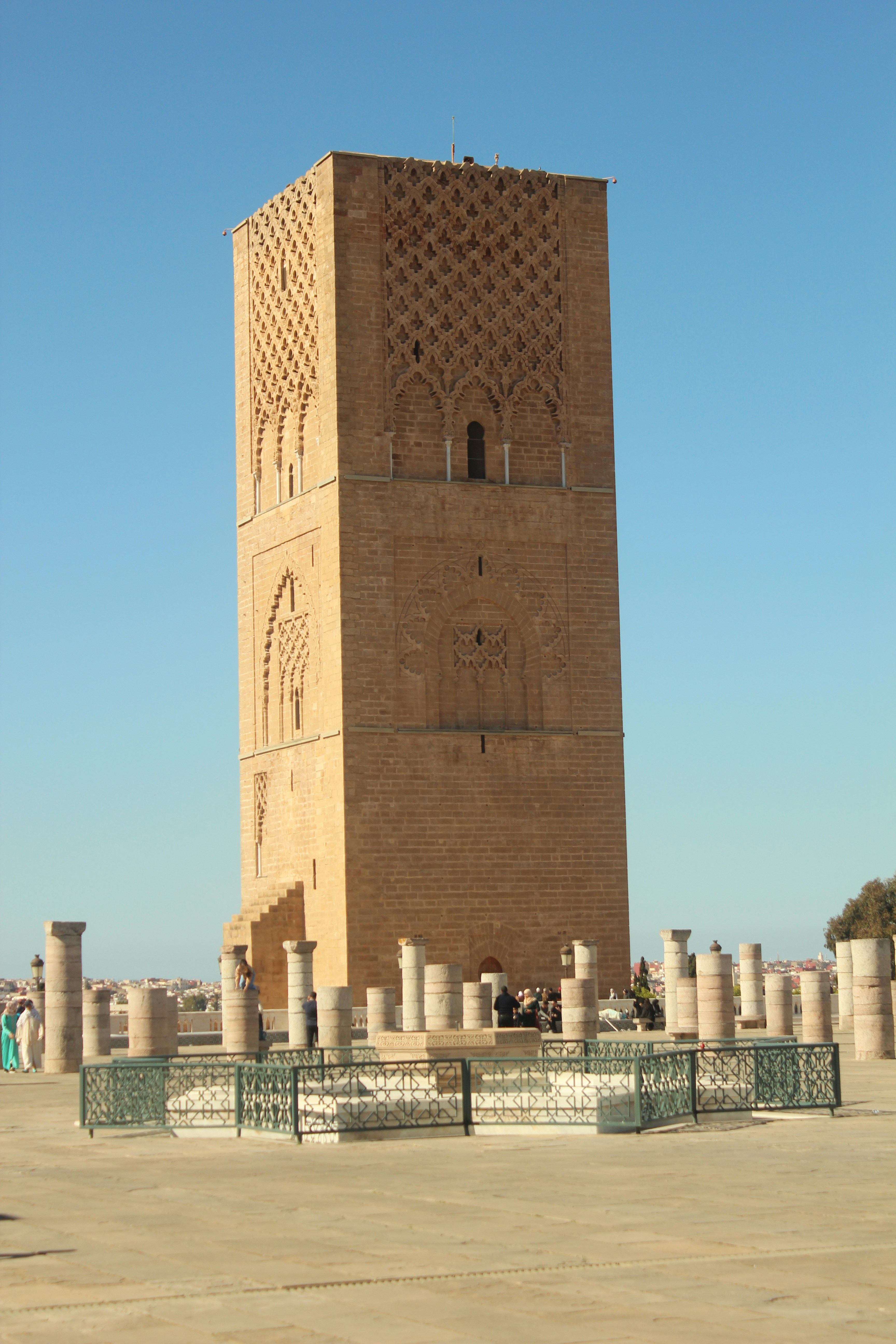 Lattice-Crowned Minaret Rising Over a Columned Plaza