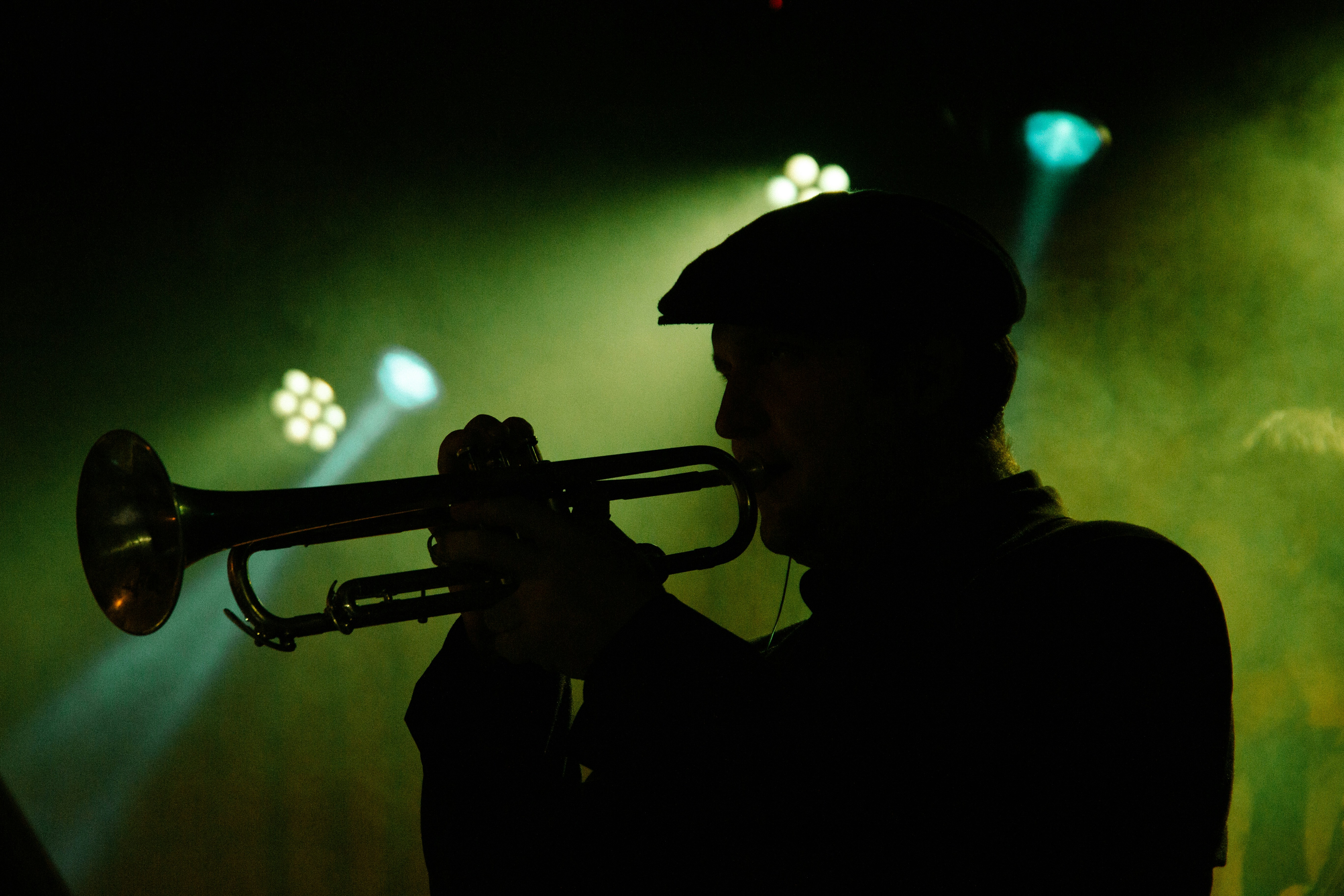 Silhouette in the Smoke: A Trumpeter Under Green-Gold Stage Light
