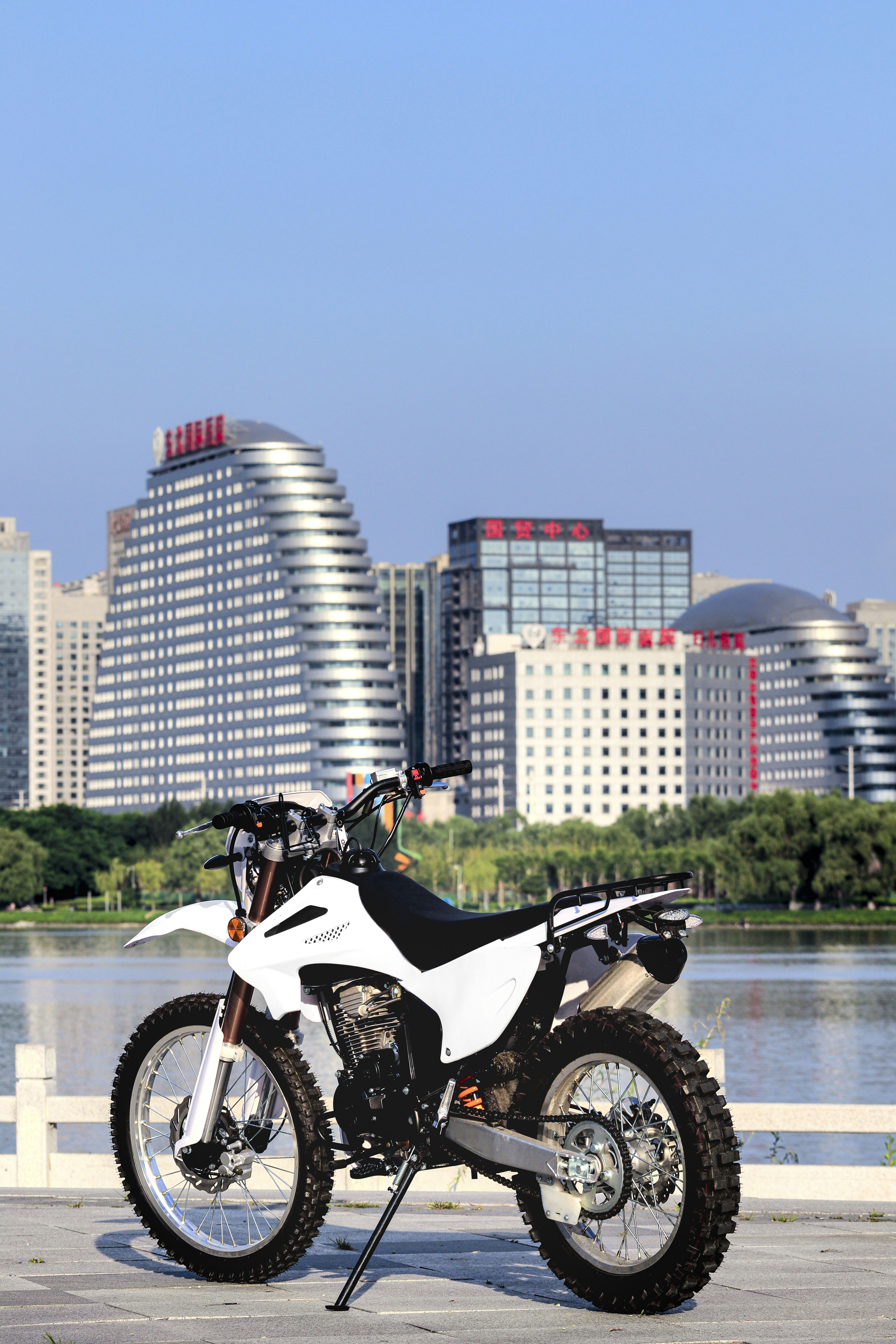 Chrome and Concrete: Dirt bike poised before a futuristic riverside skyline