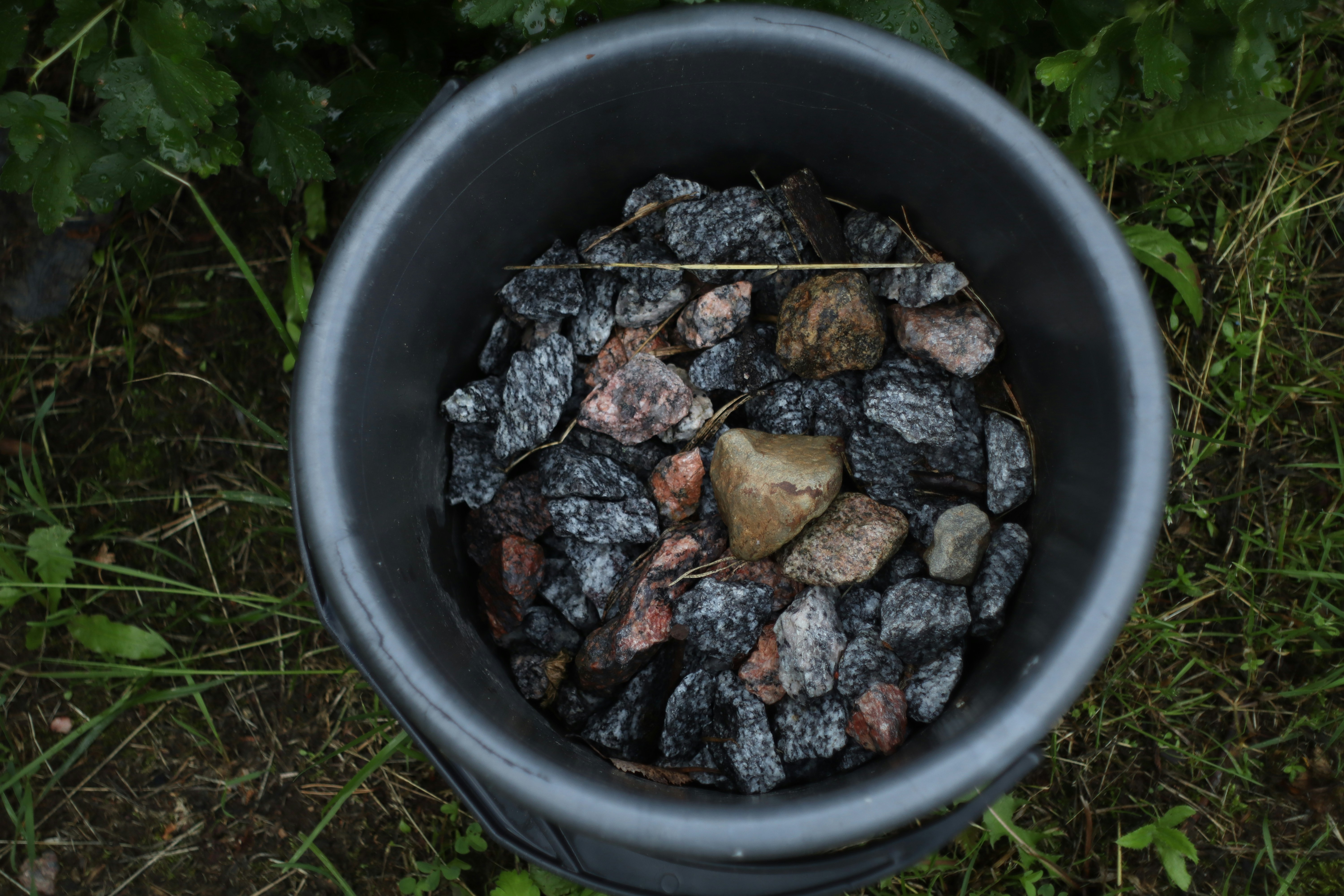 Top-Down Pebble Cache in a Matte Black Bucket
