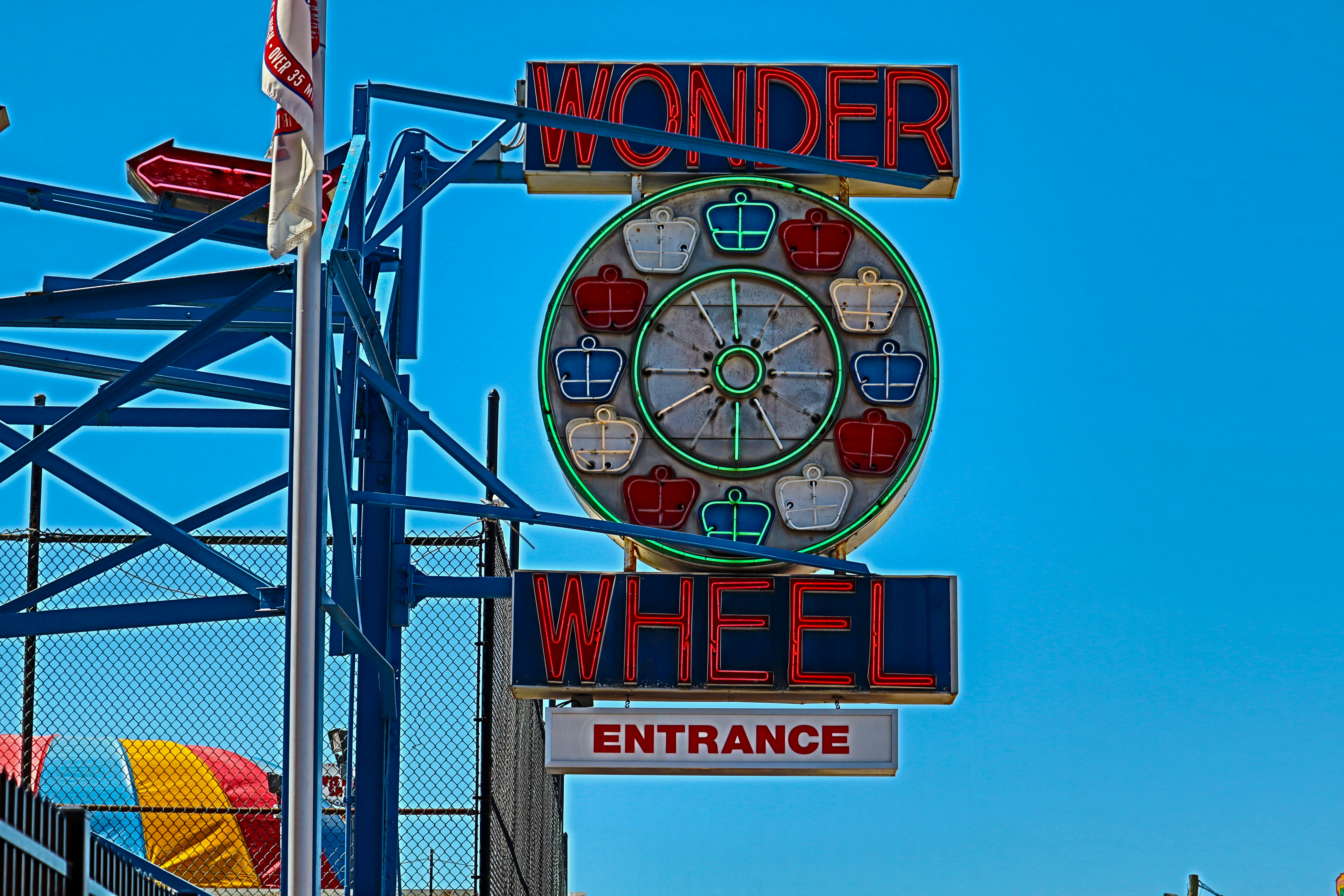 a sign with a ferris wheel in the background