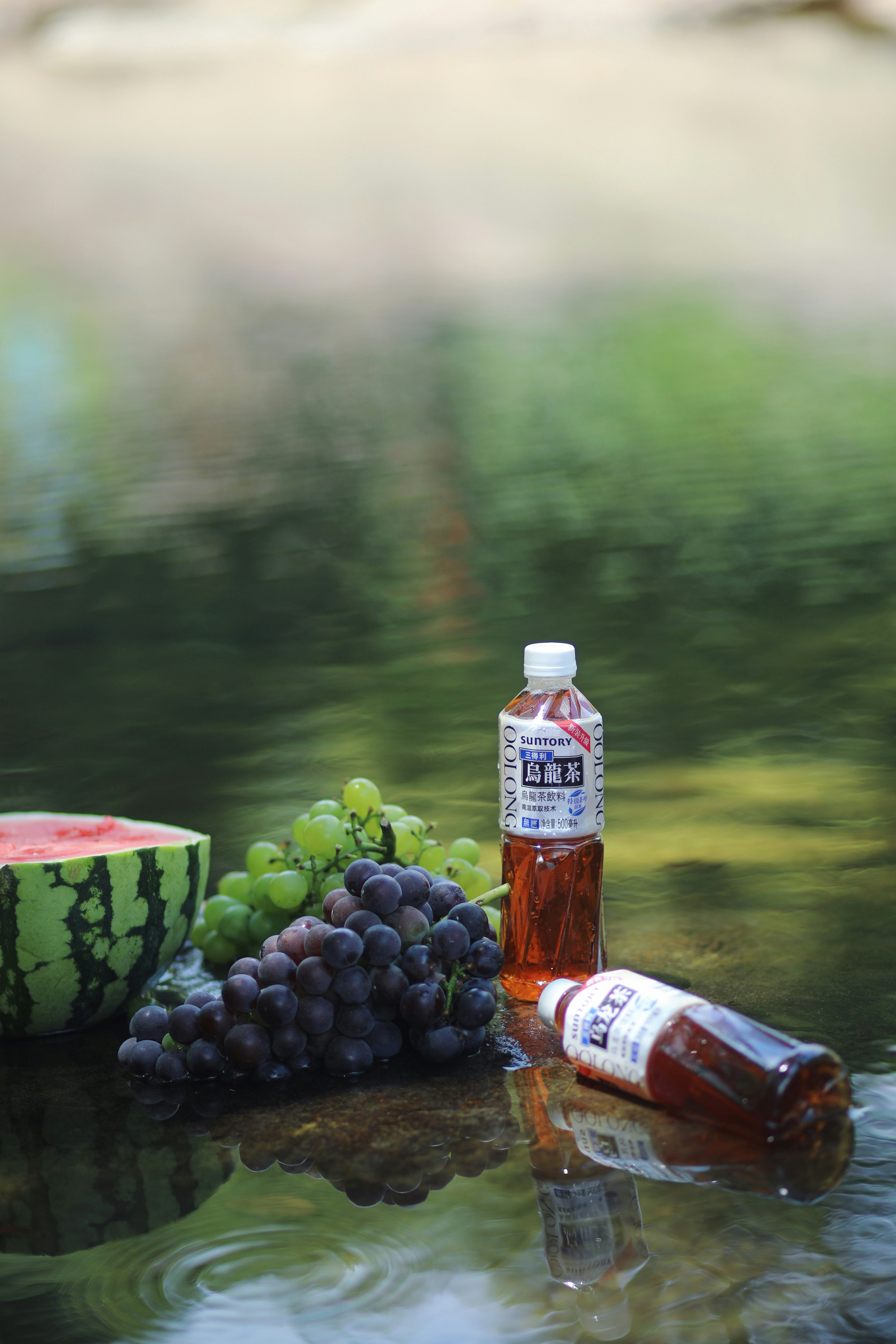 a bottle of alcohol next to a bowl of grapes and a bottle of liquor