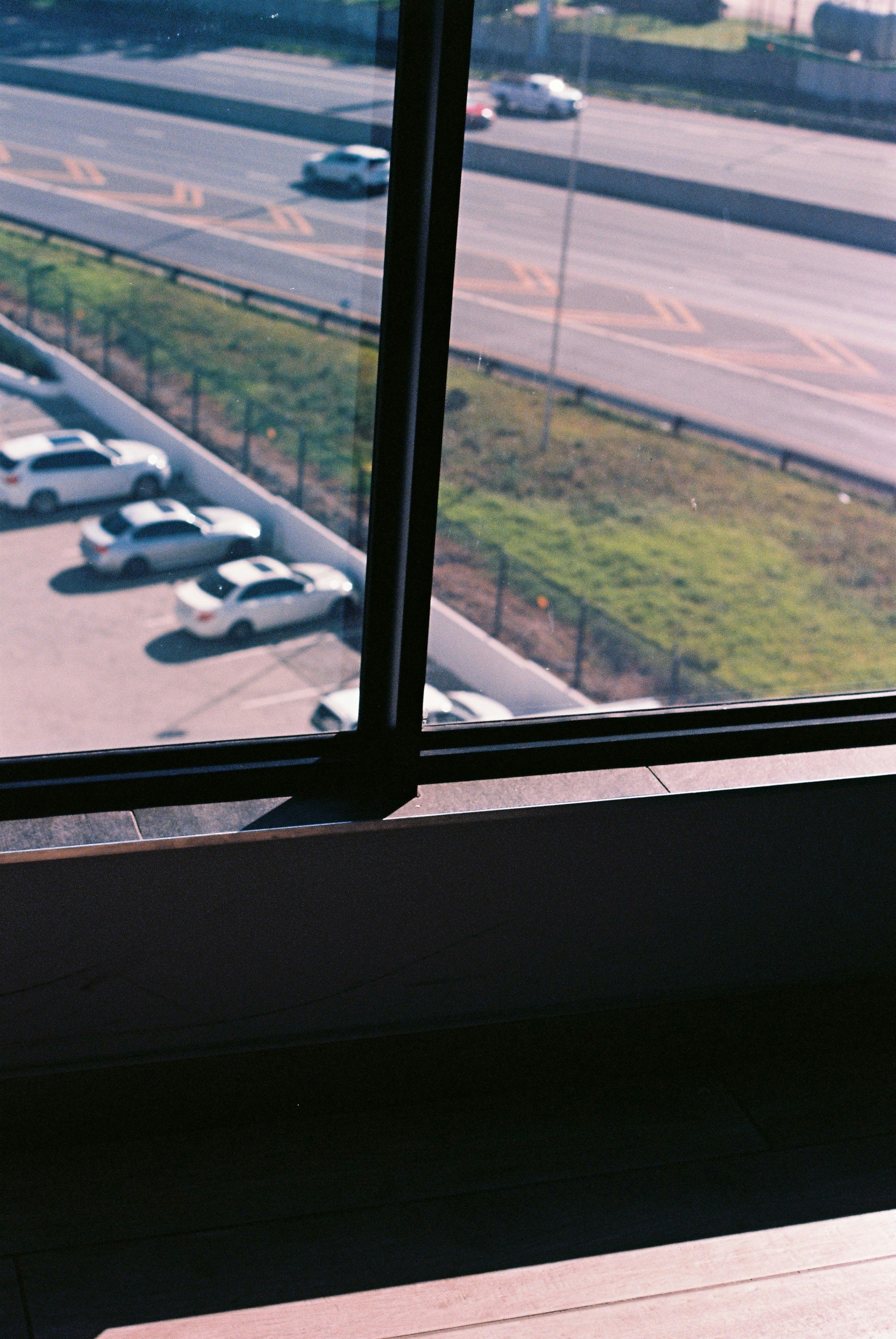 Mullion Geometry: Sunlit Parking Lot Beyond a Window