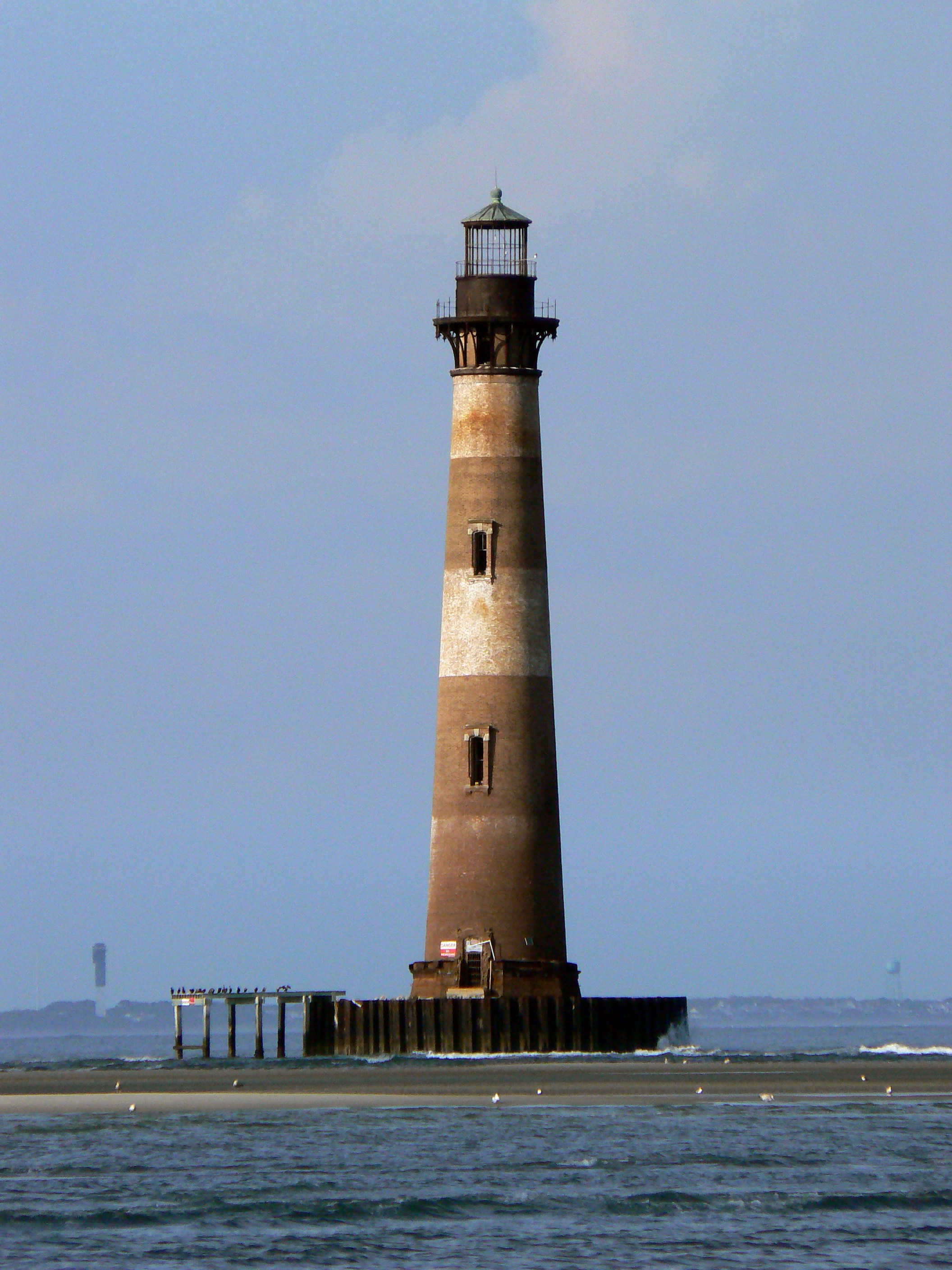 A lighthouse on a pier photo – Free Morris island lighthouse Image on ...