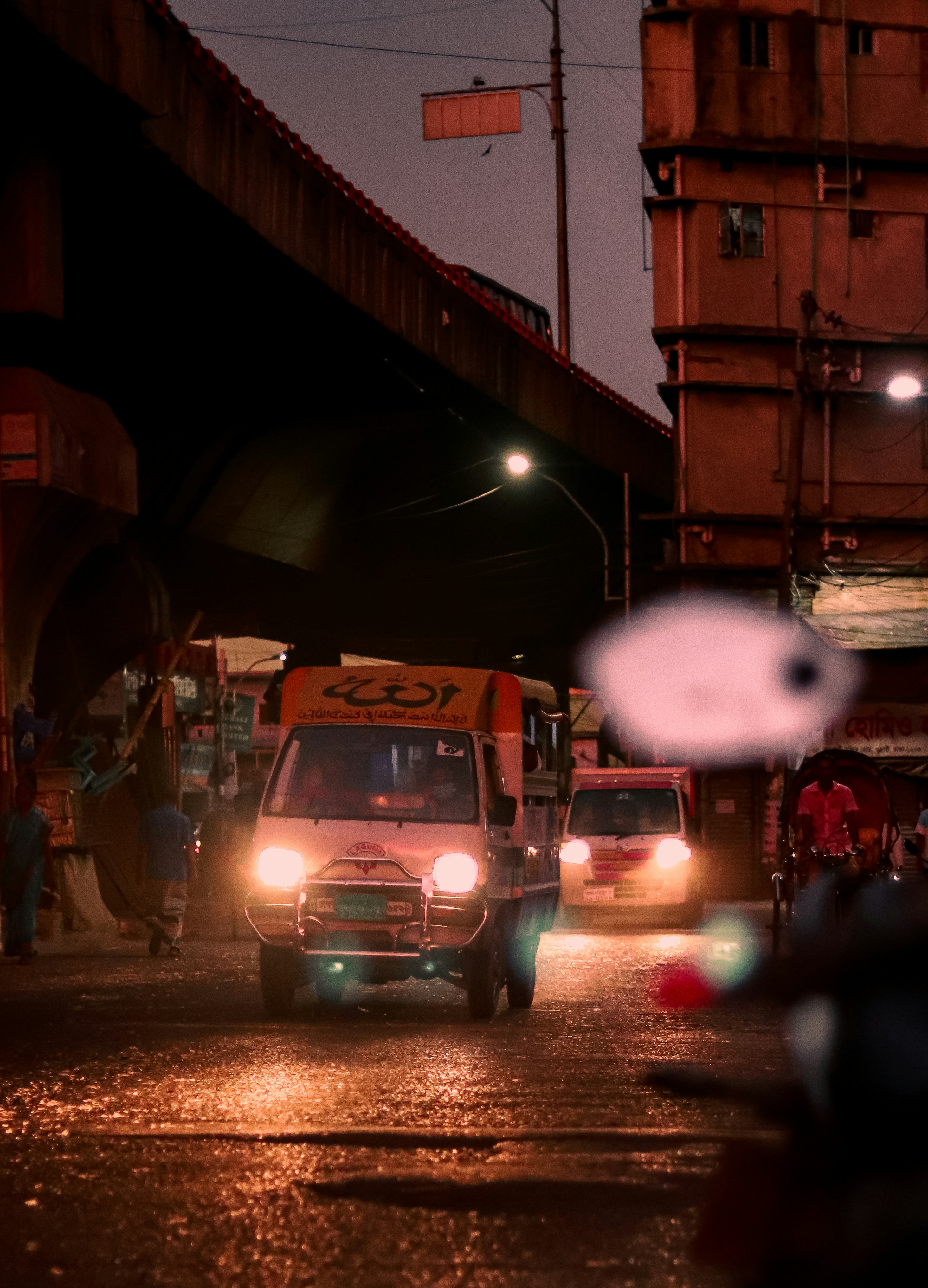 Underpass Run: A White Van Leads Through a Rain-Wet Neon Street