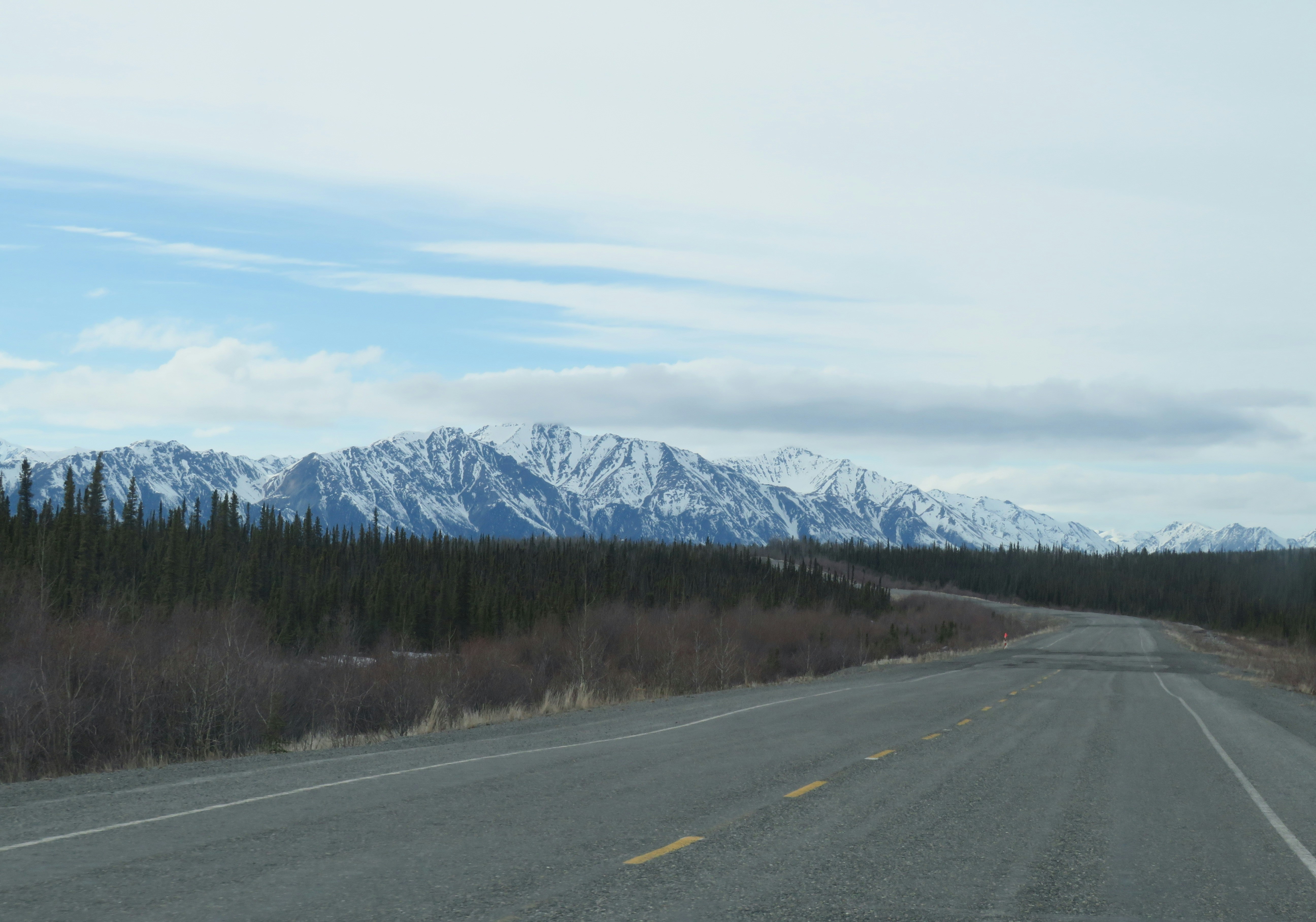 Deserted Highway Toward Snow-Kissed Peaks
