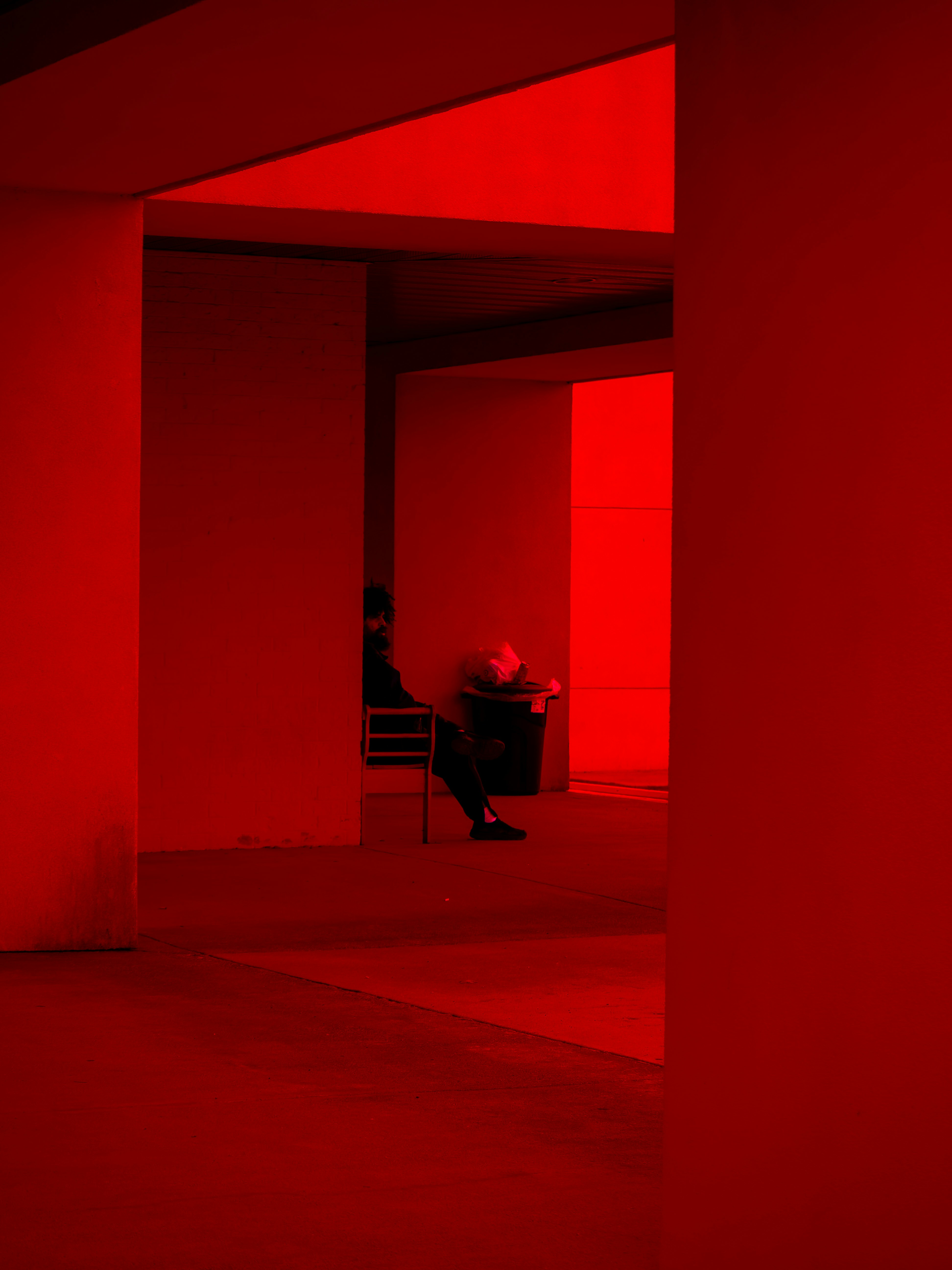 Crimson Corridor Solitude: a lone silhouette among glowing pillars
