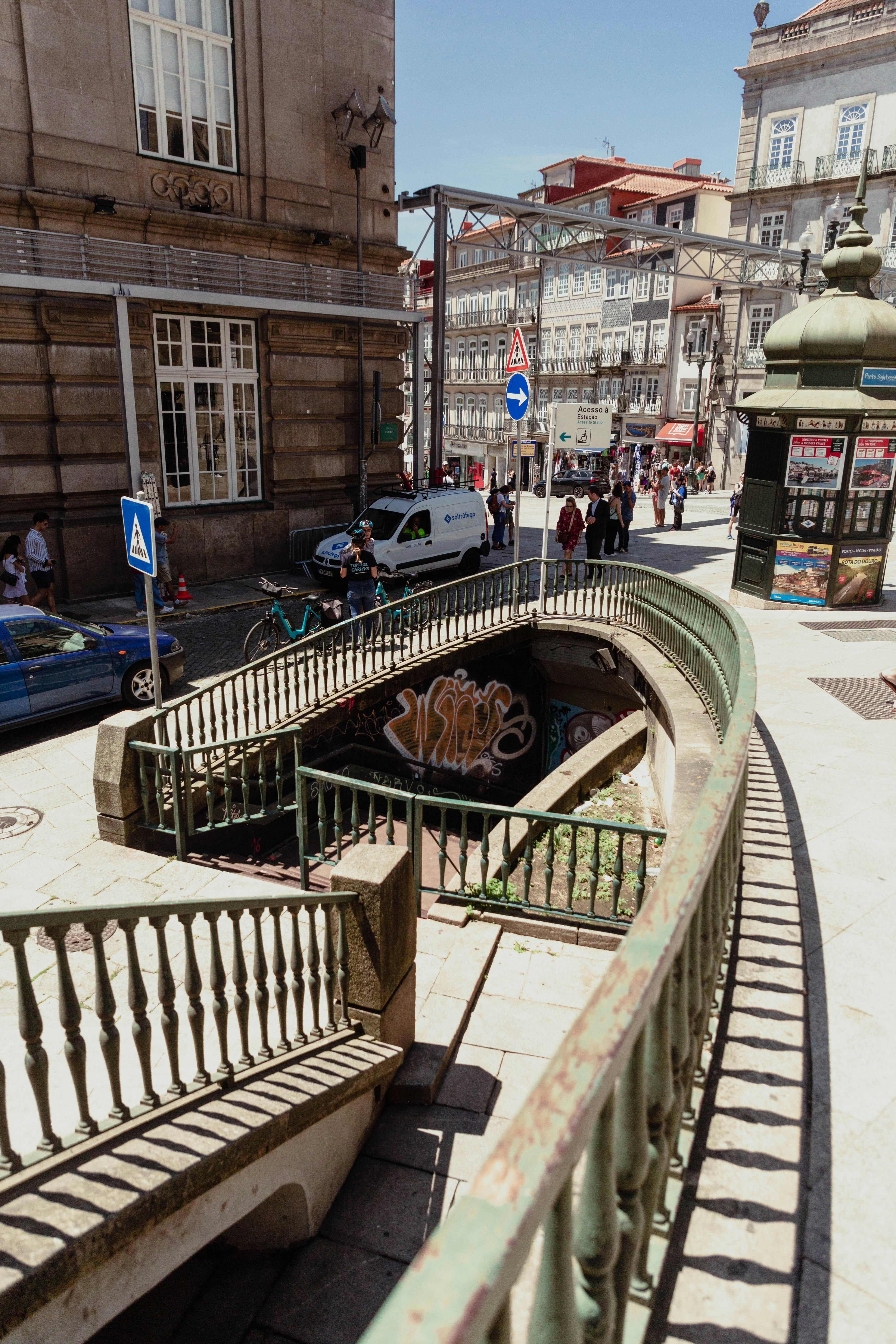 Sunlit Curve: Pedestrians Framed by a Graffiti-Strewn Stairwell