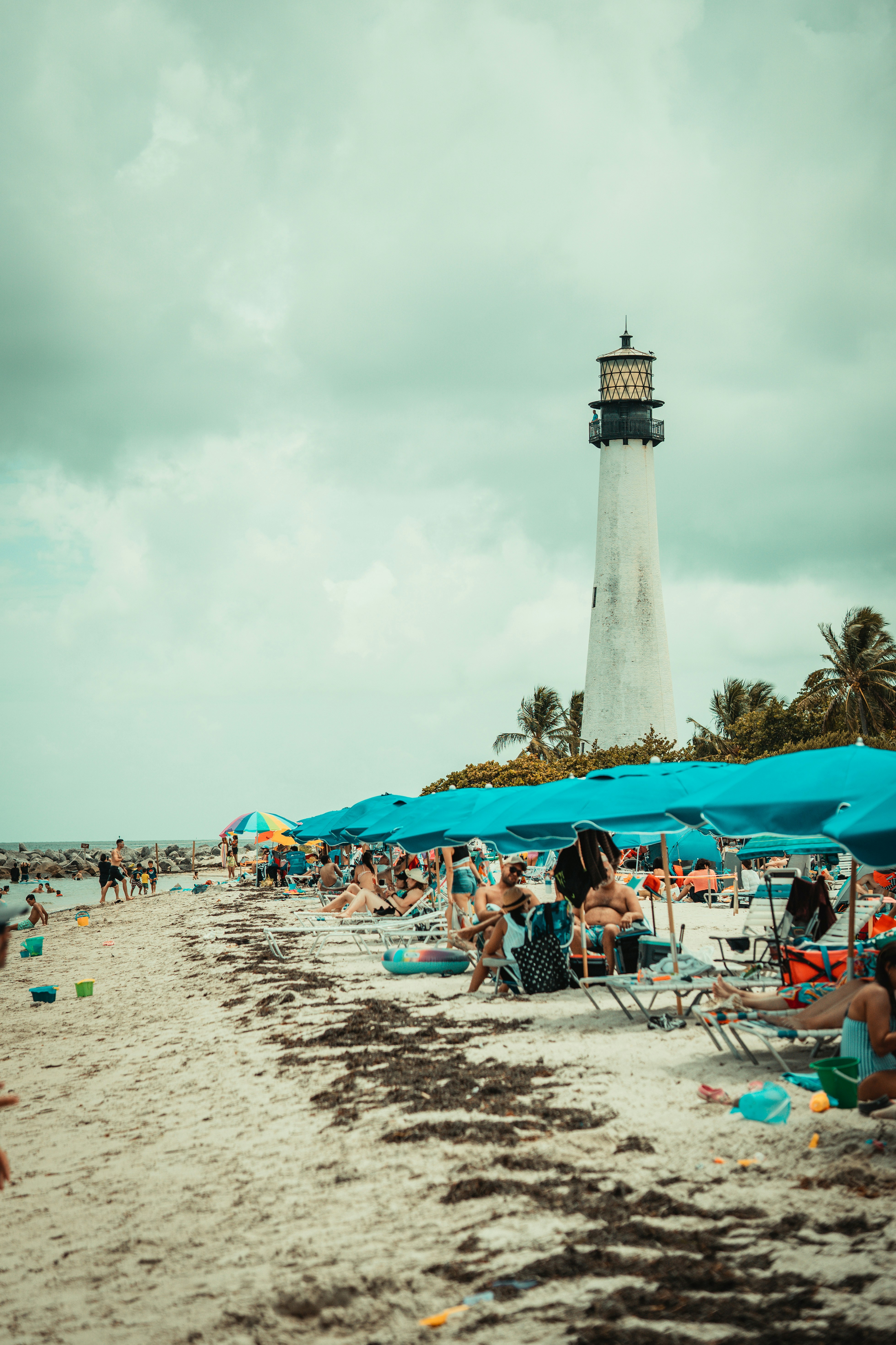 Lighthouse Watch Amid a Sea of Turquoise Umbrellas