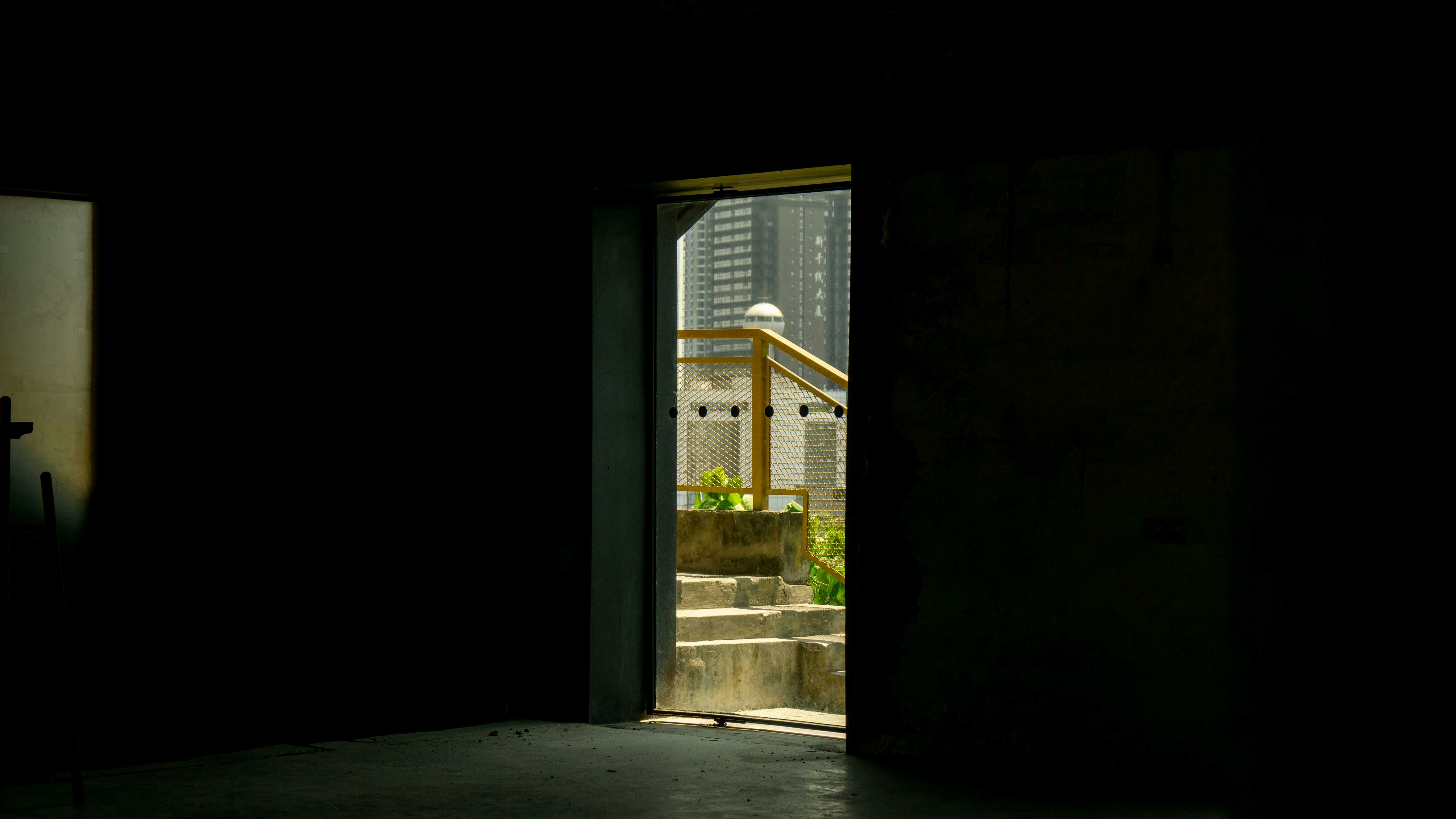 Threshold of Light: Sunlit Stairs Framed by a Shadowed Doorway