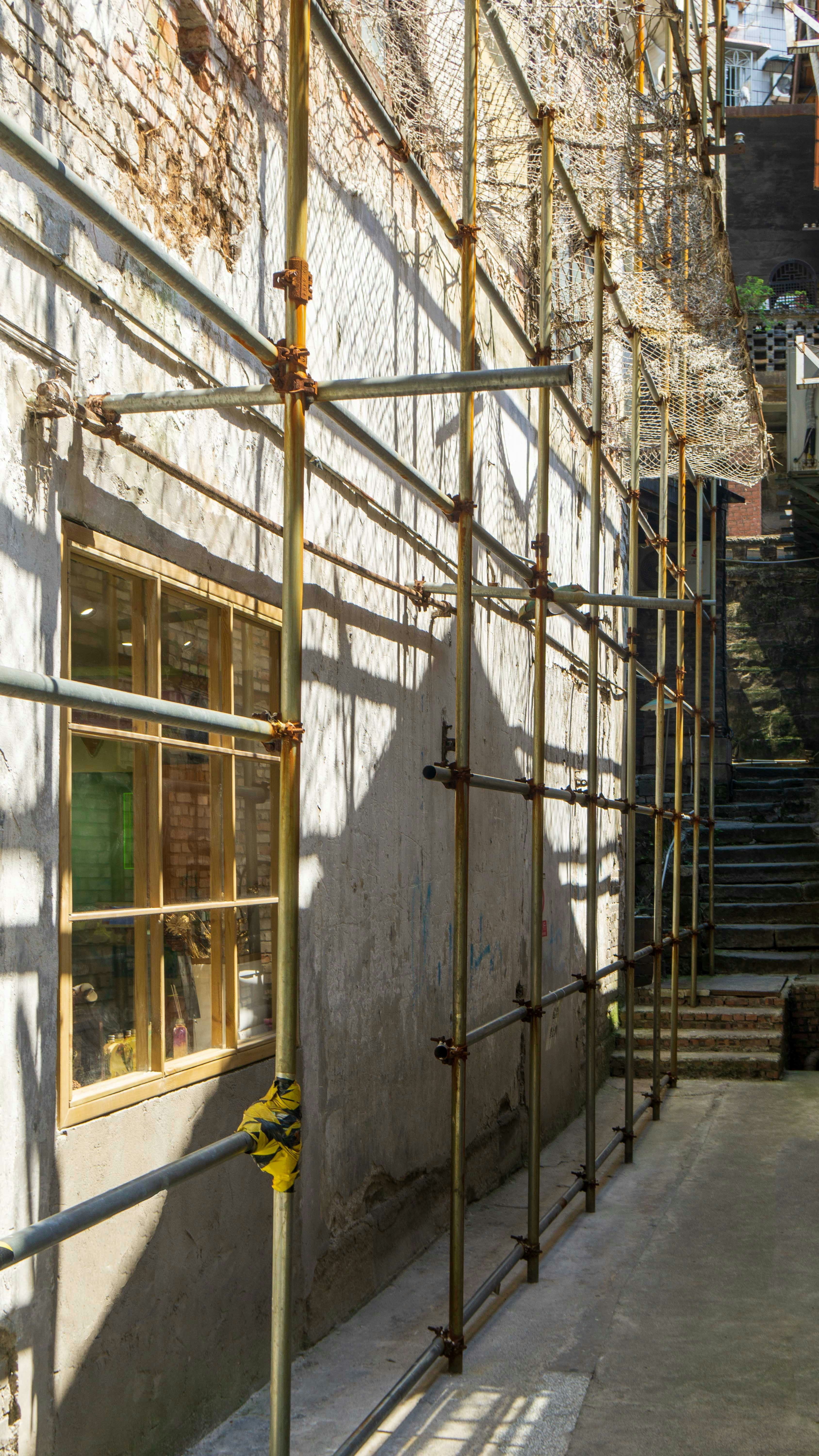 Scaffolding Cast Shadows Along a Weathered Wall