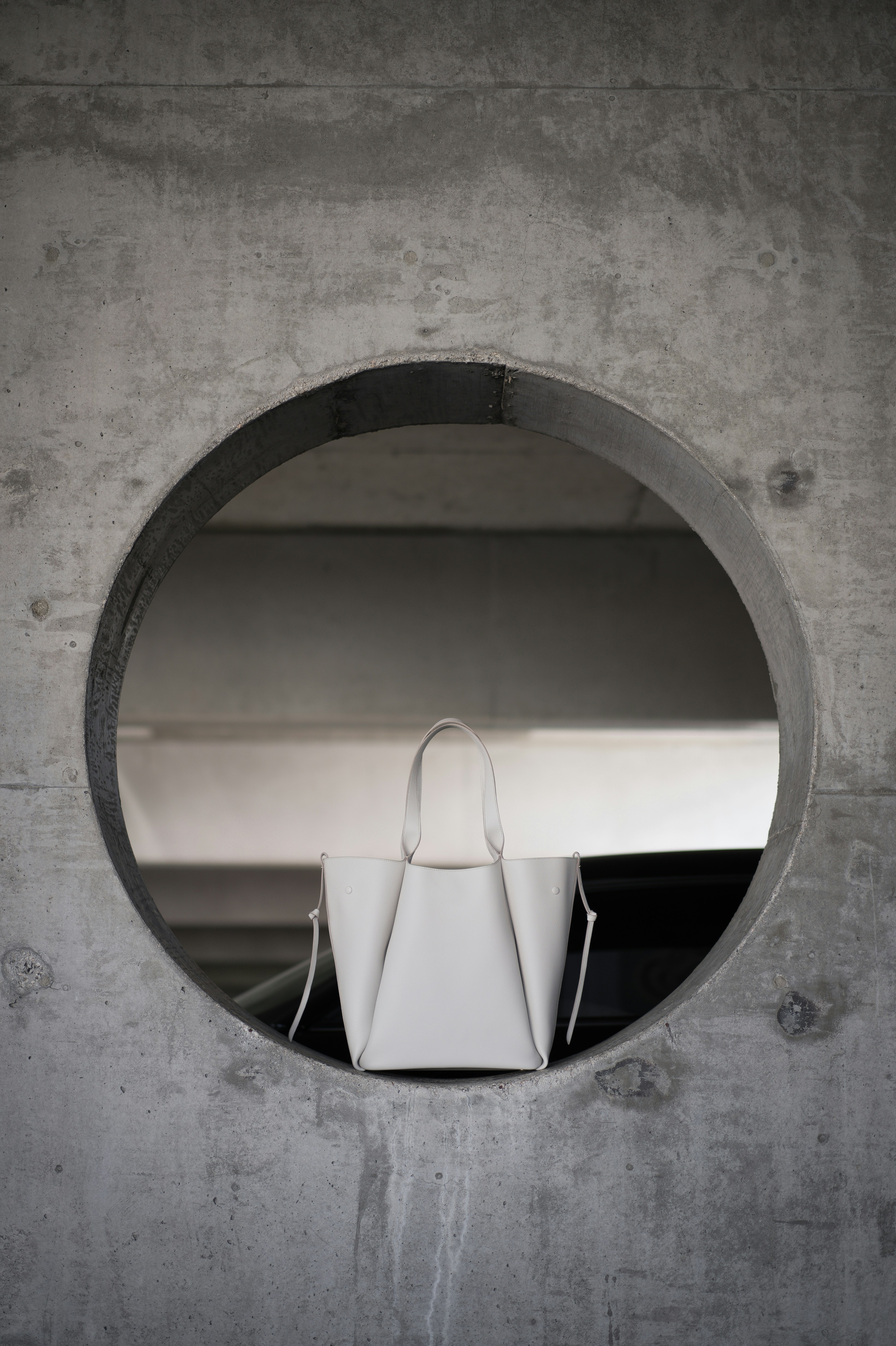 Circle of Quiet: A White Tote Framed by Concrete