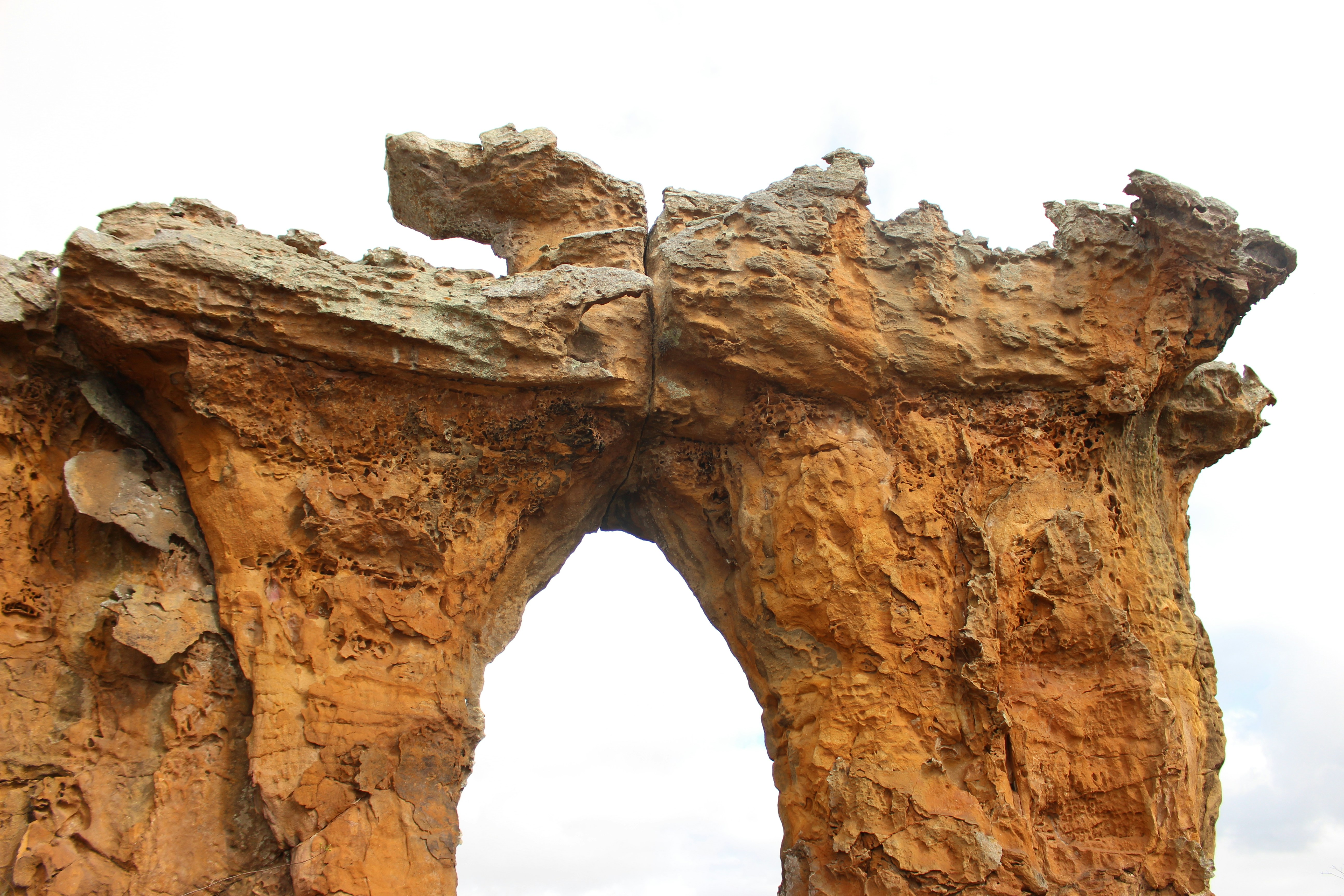 Weathered sandstone arch: a natural doorway to the pale sky
