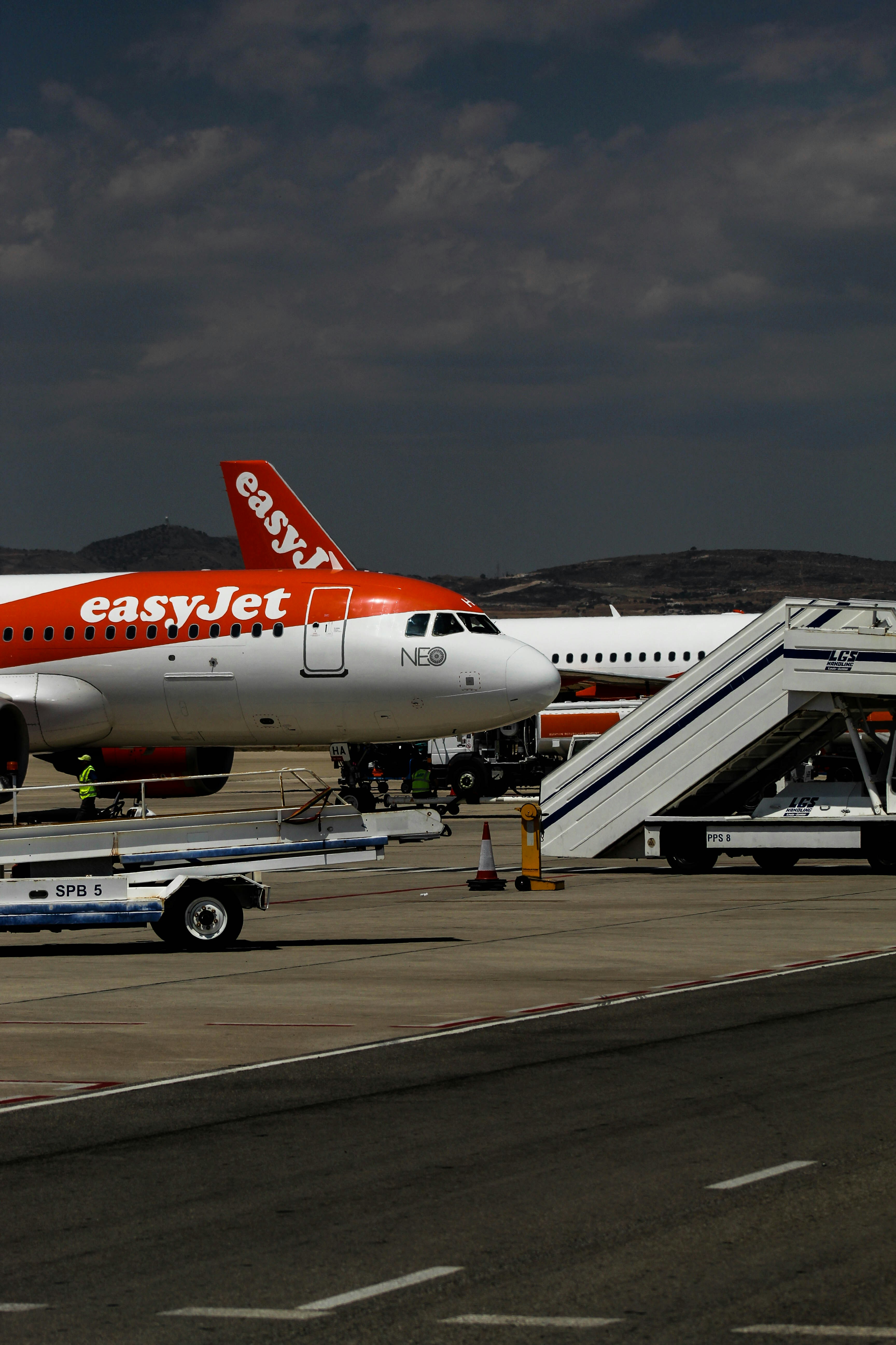 Orange-tail EasyJet at the gate on a sunlit apron