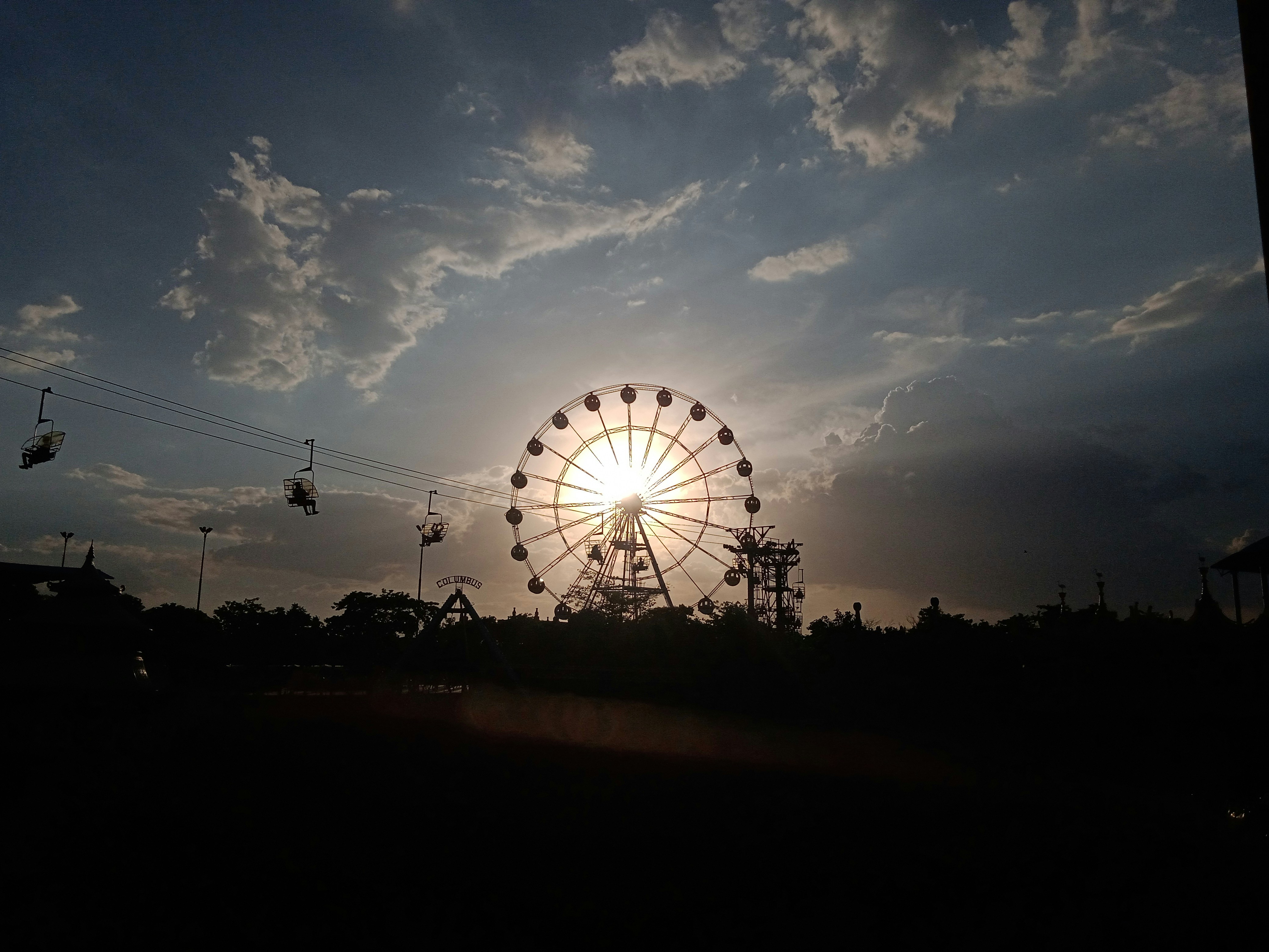 a ferris wheel with a sunset in the background