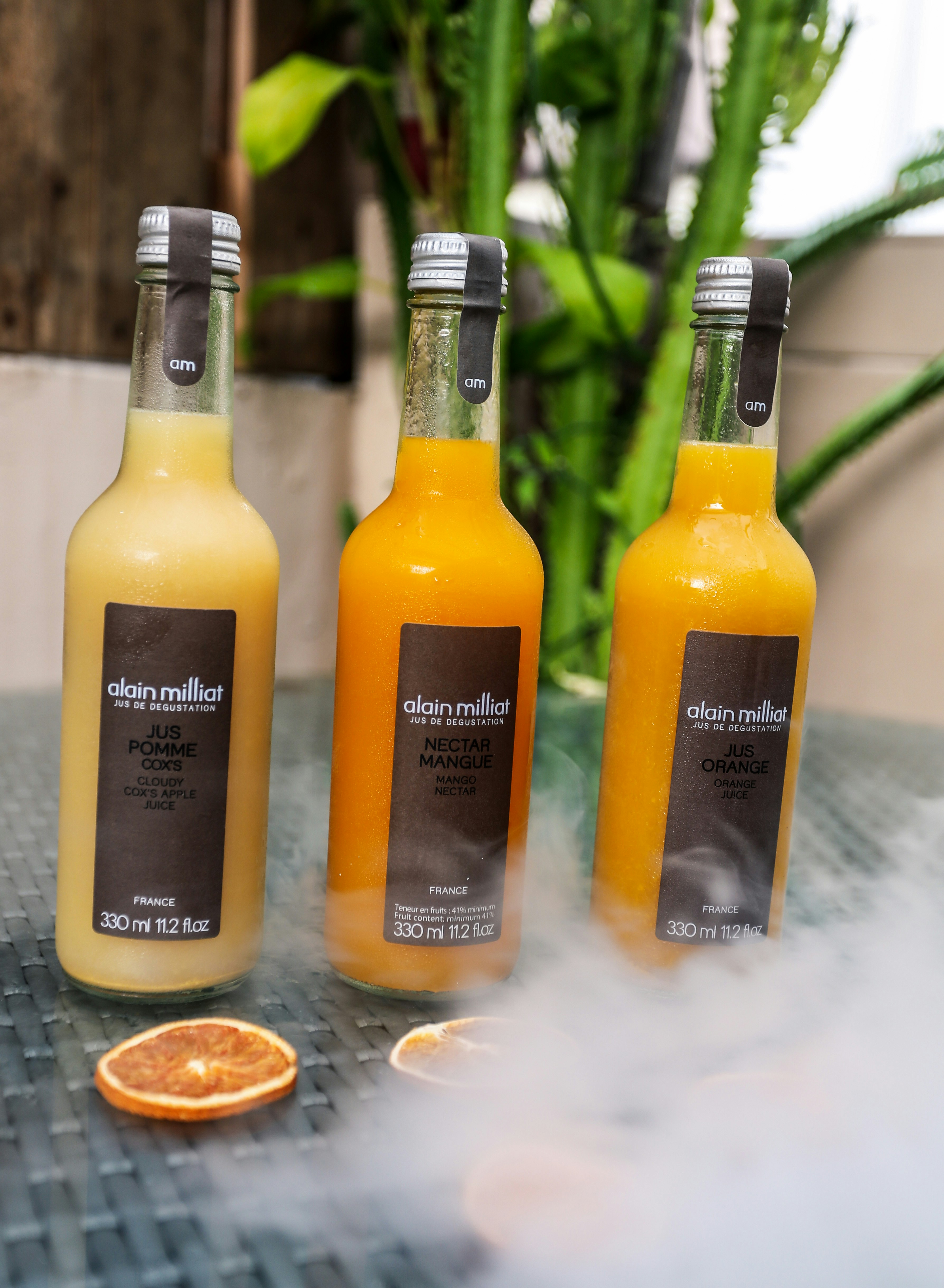 Three Bottles of Juice Stand Tall on a Metal Table