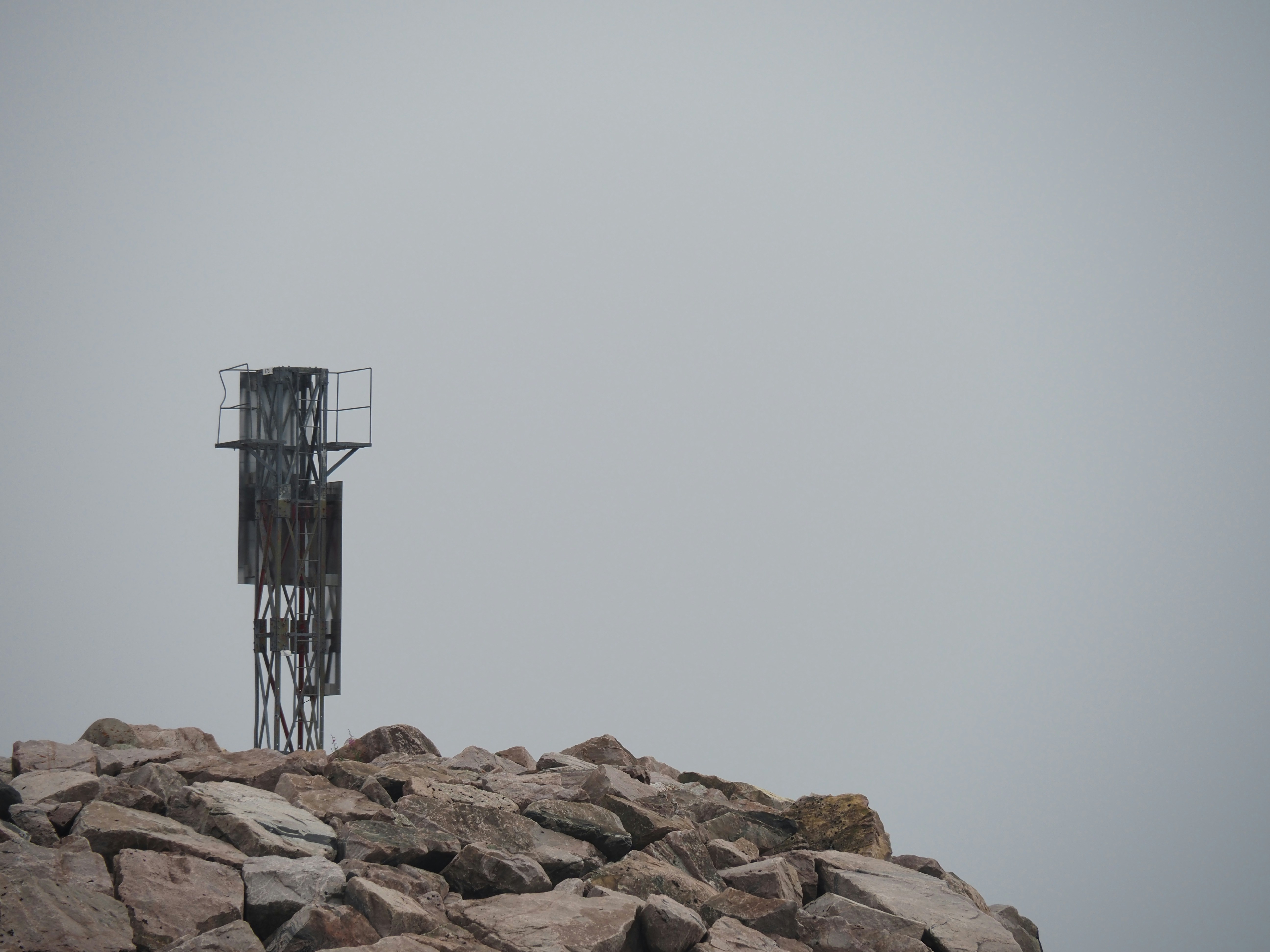 Lone Iron Sentinel on a Rugged Breakwater