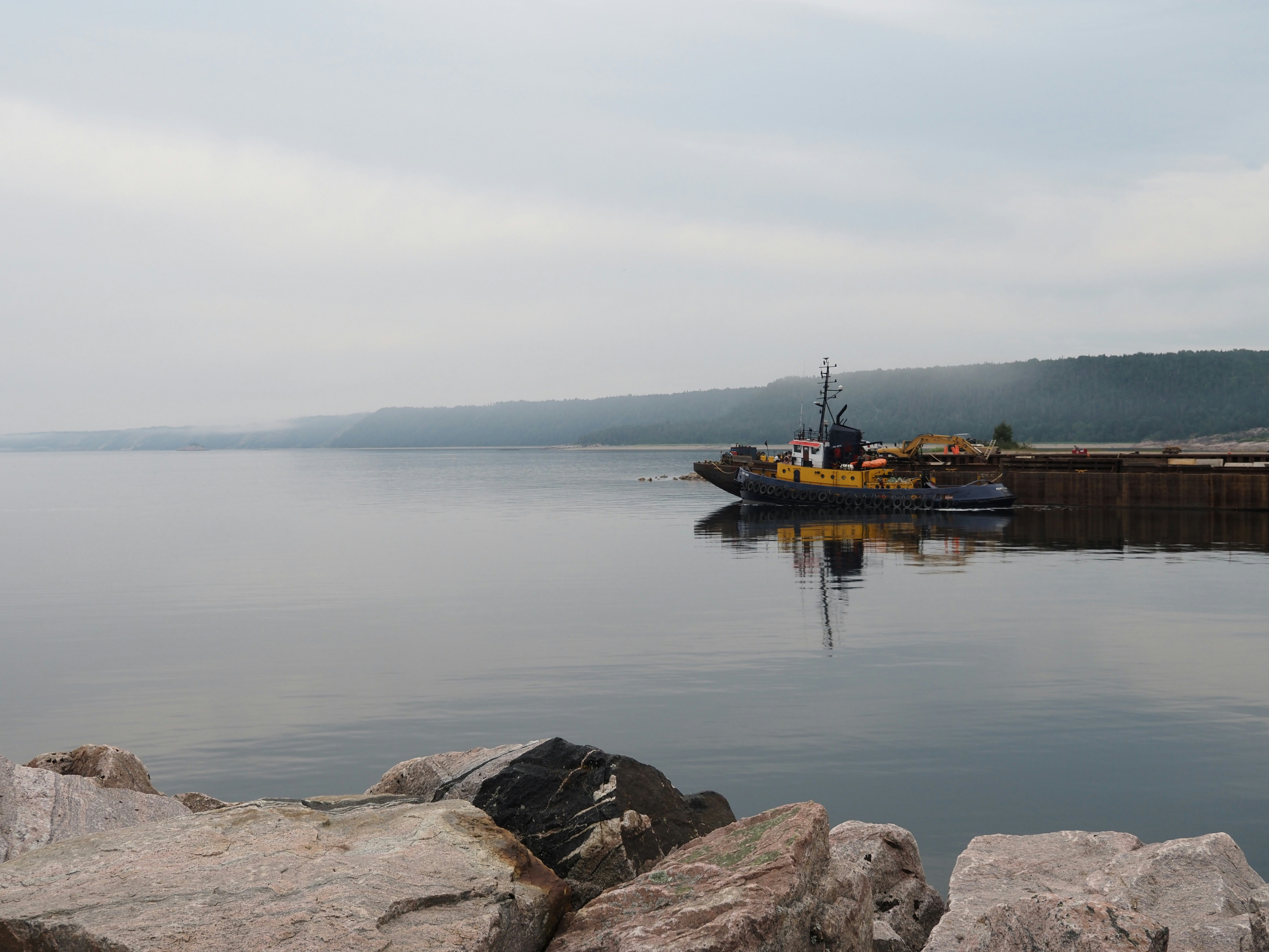 Quiet Harbor Tug Beside a Glassy Inlet