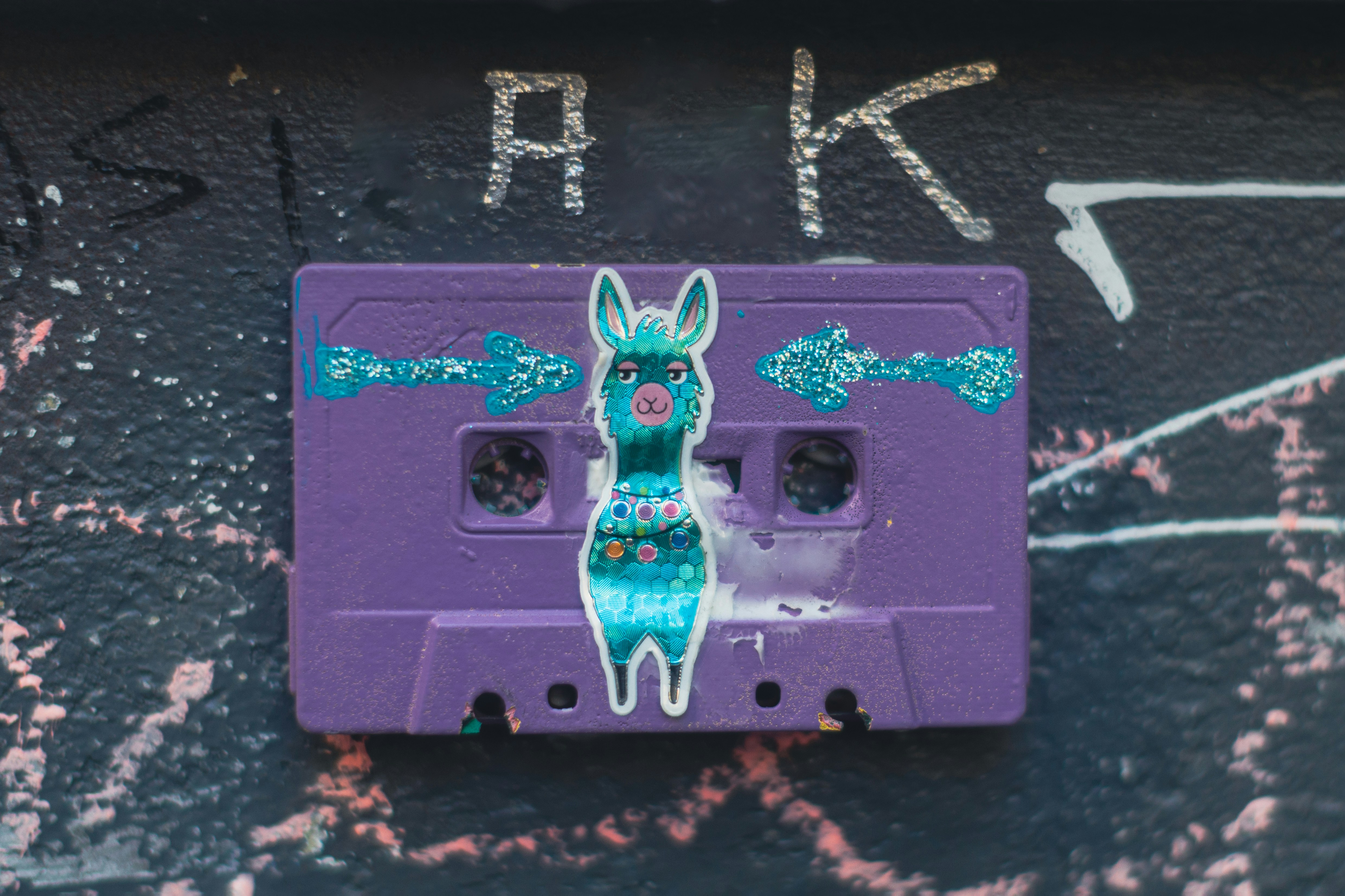 Llama on a Retro Cassette: Neon Sticker Amid Chalk Graffiti