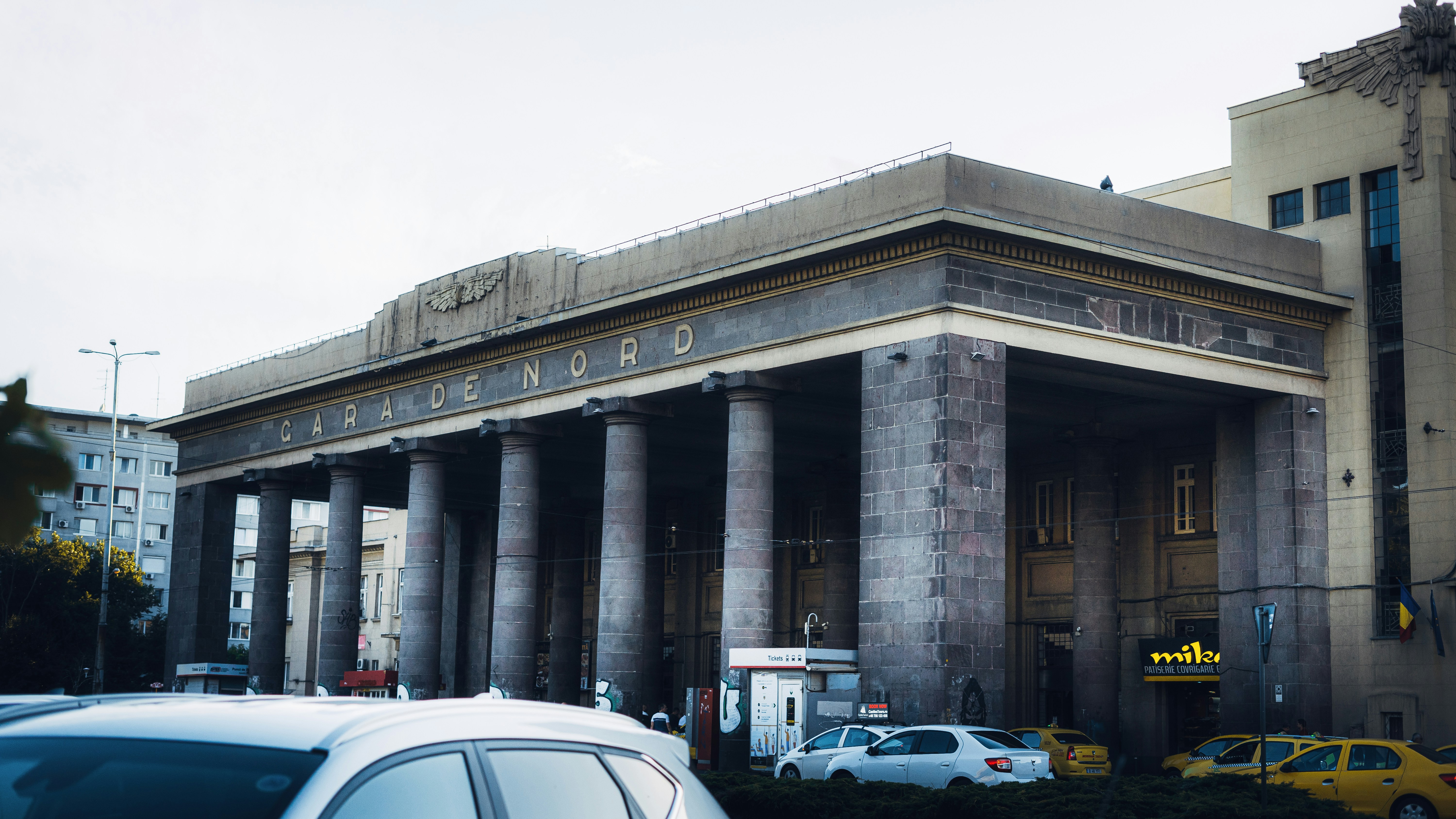 A building with columns and cars in front of it photo – Free Bucharest ...