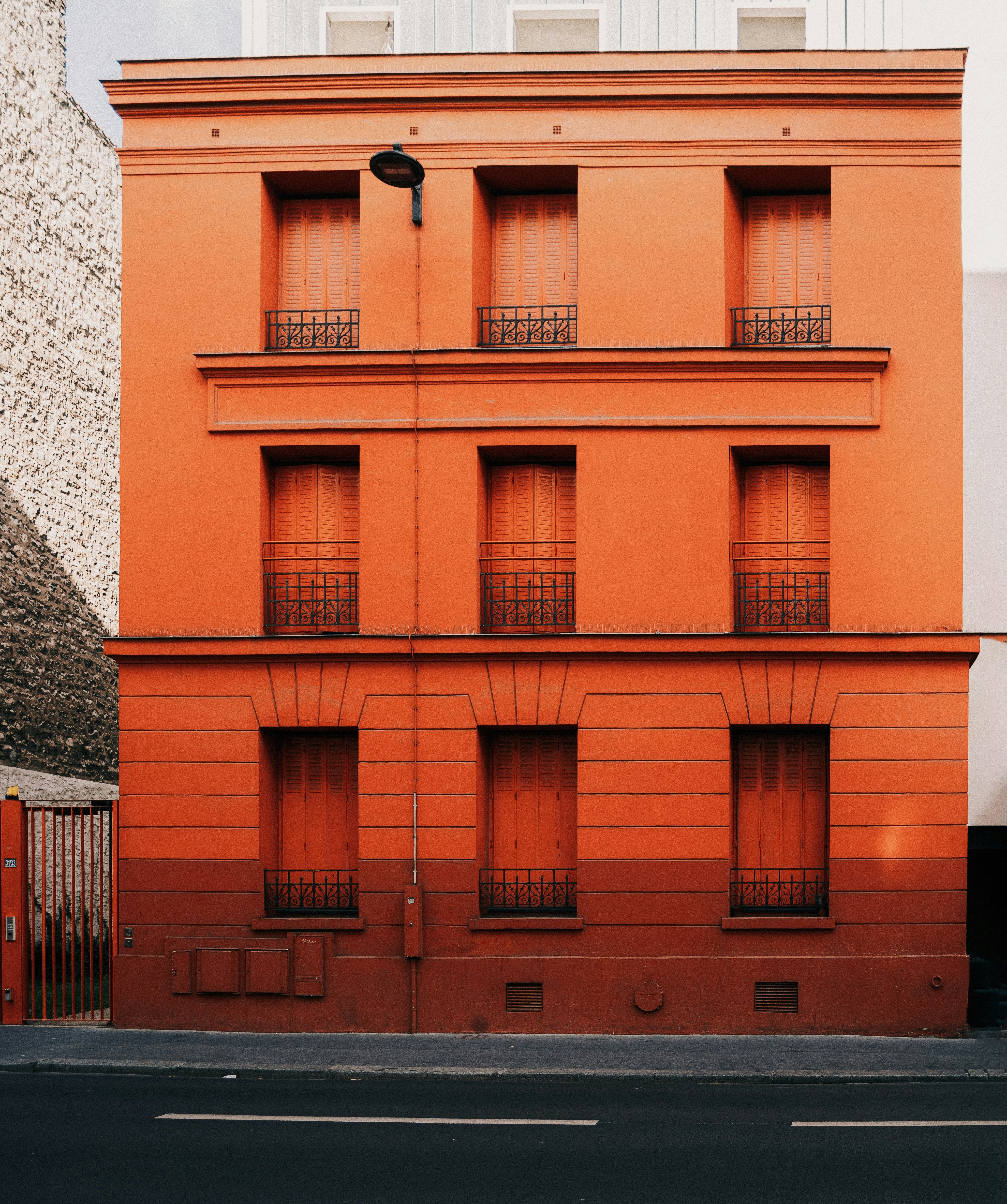 Scarlet Facade: Symmetry and Sunlight on a City Brick Block