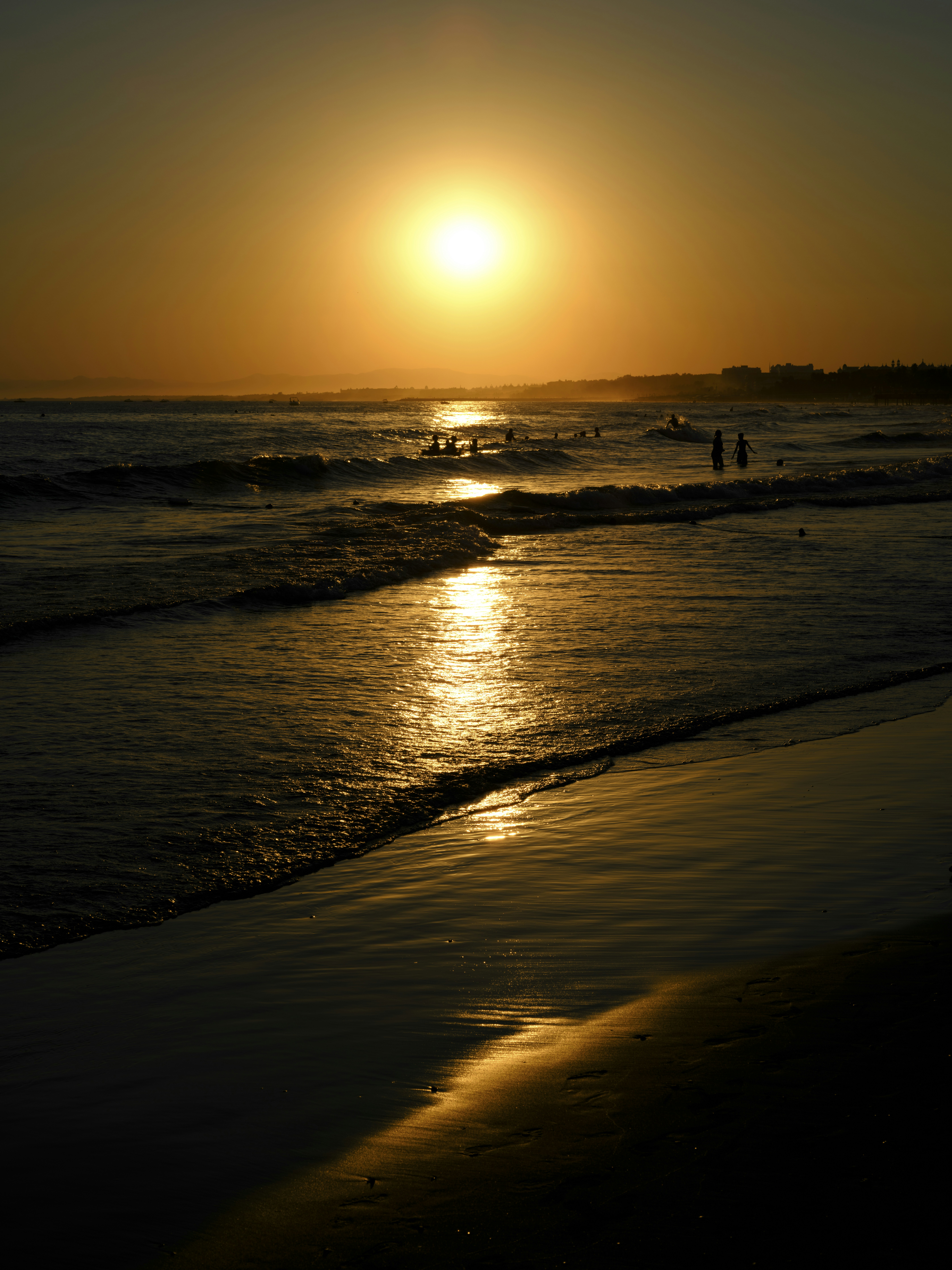 A beach with people and the sun setting photo – Free Outdoors Image on ...