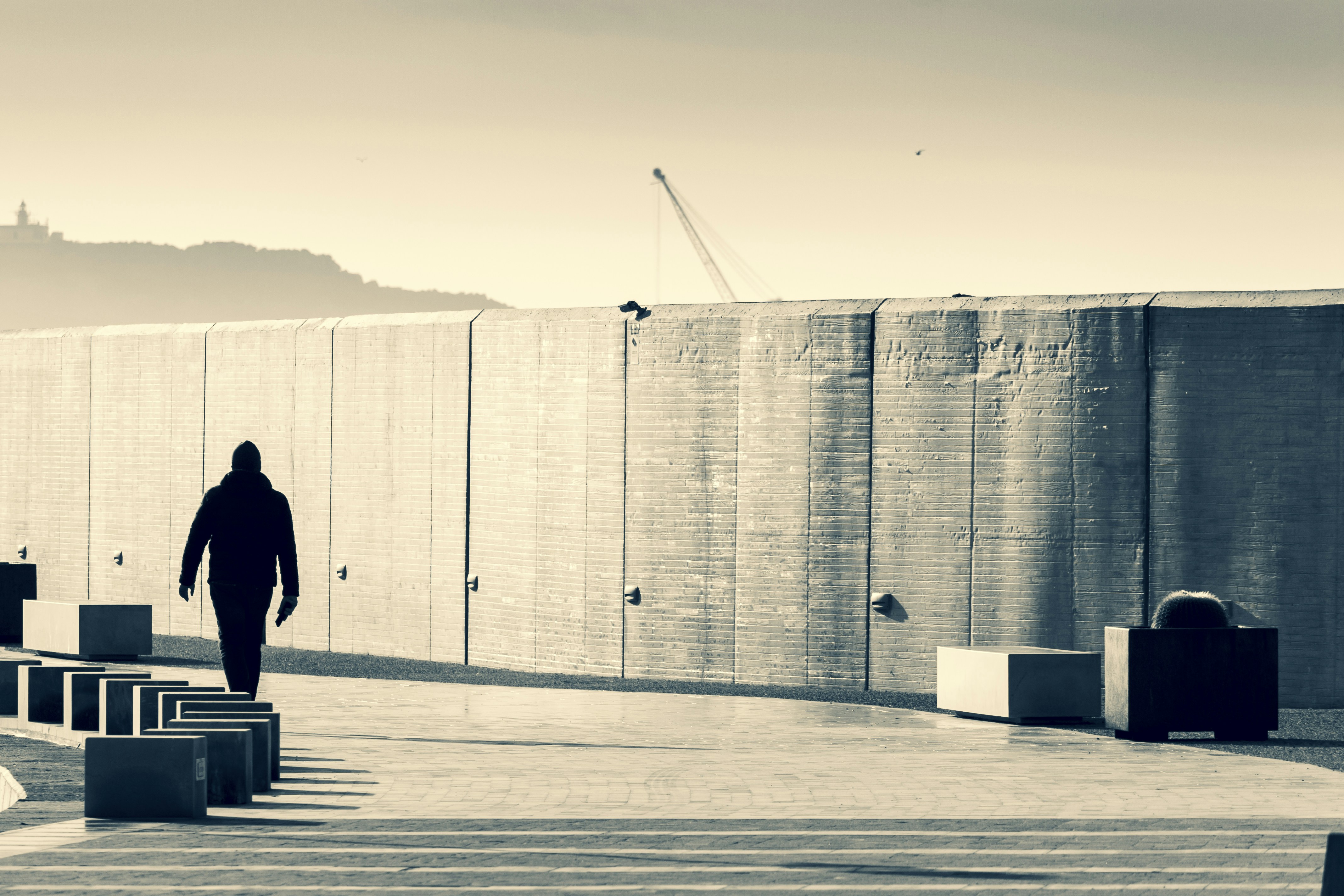 Un homme marchant devant un grand mur de béton photo – Photo Carthagène ...
