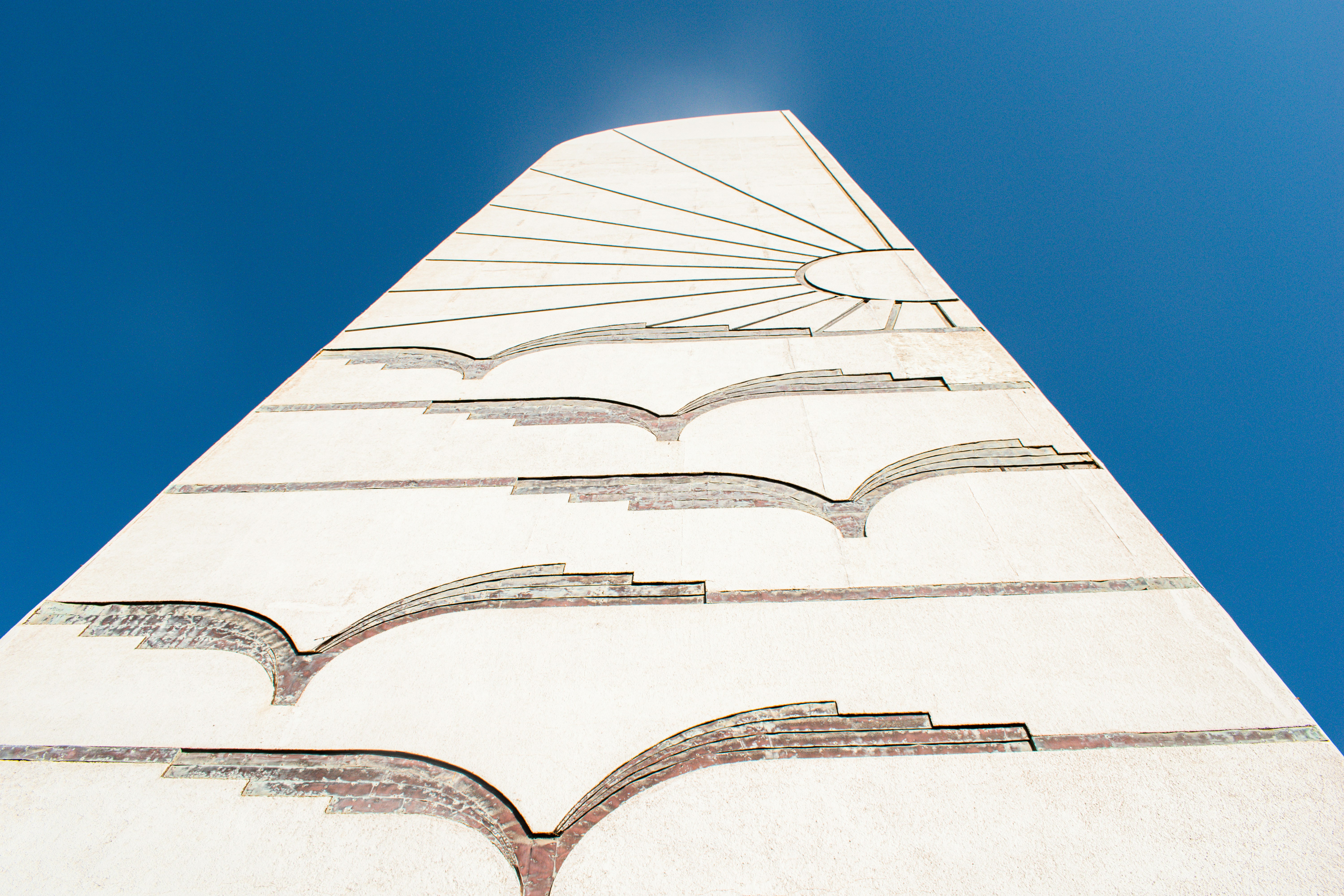 Rising Facade: A White Monolith Reaching Toward a Cerulean Sky