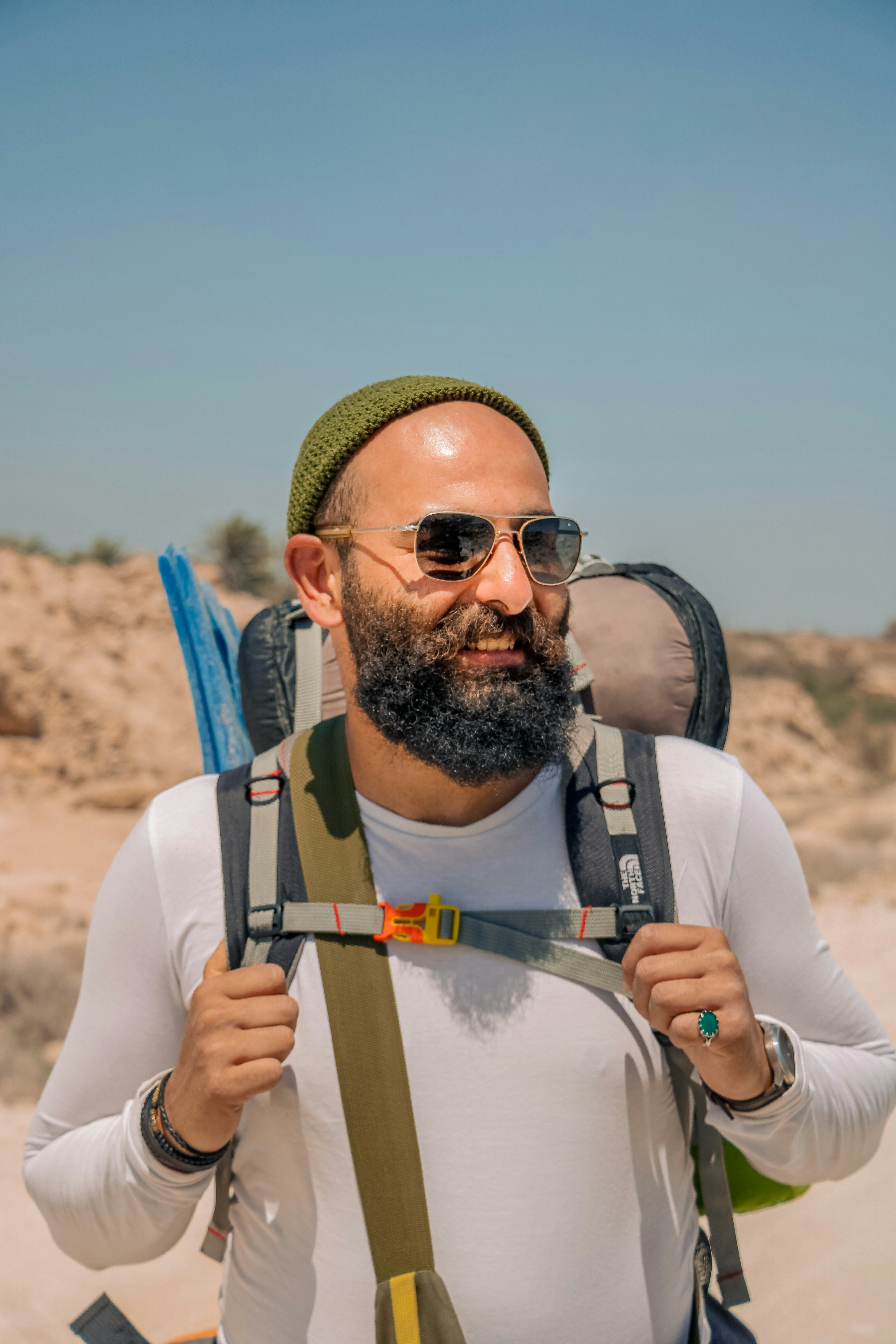 Bearded Trekker in Olive Beanie: Portrait Under a Desert Sky