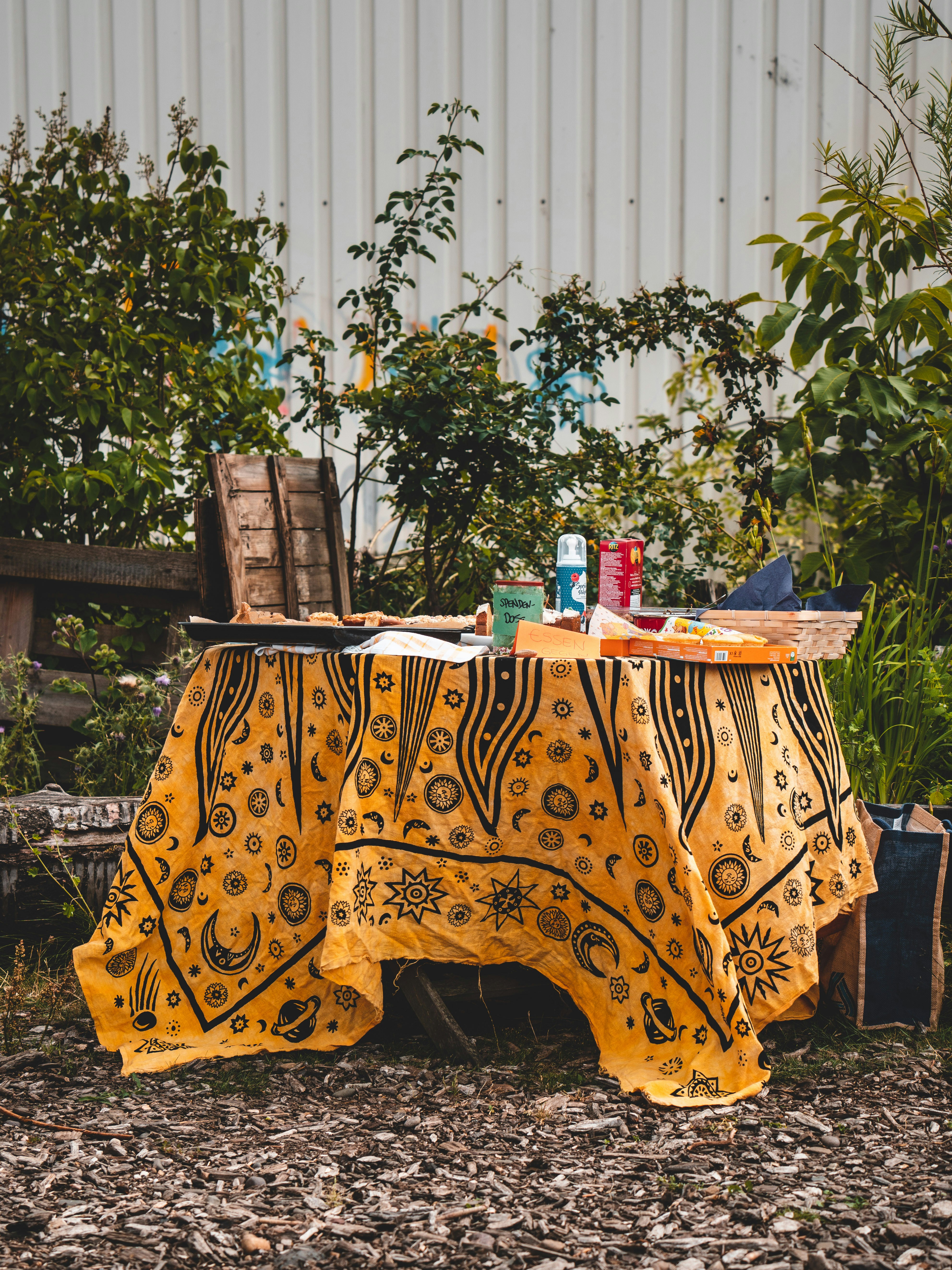 Sunlit Yellow Cloth Draped Over a Weathered Backyard Table