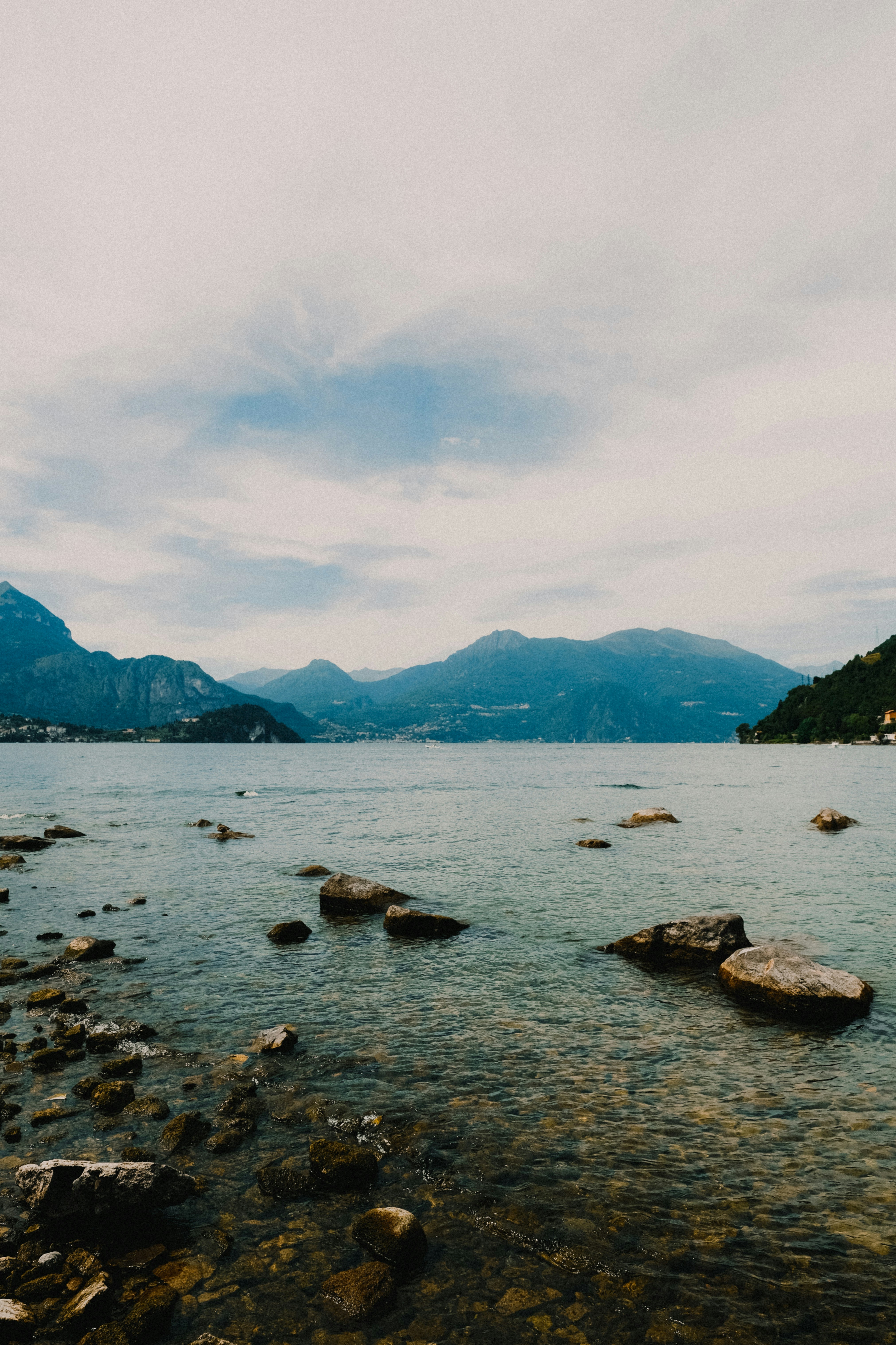 A rocky beach with mountains in the background photo – Free Province of ...