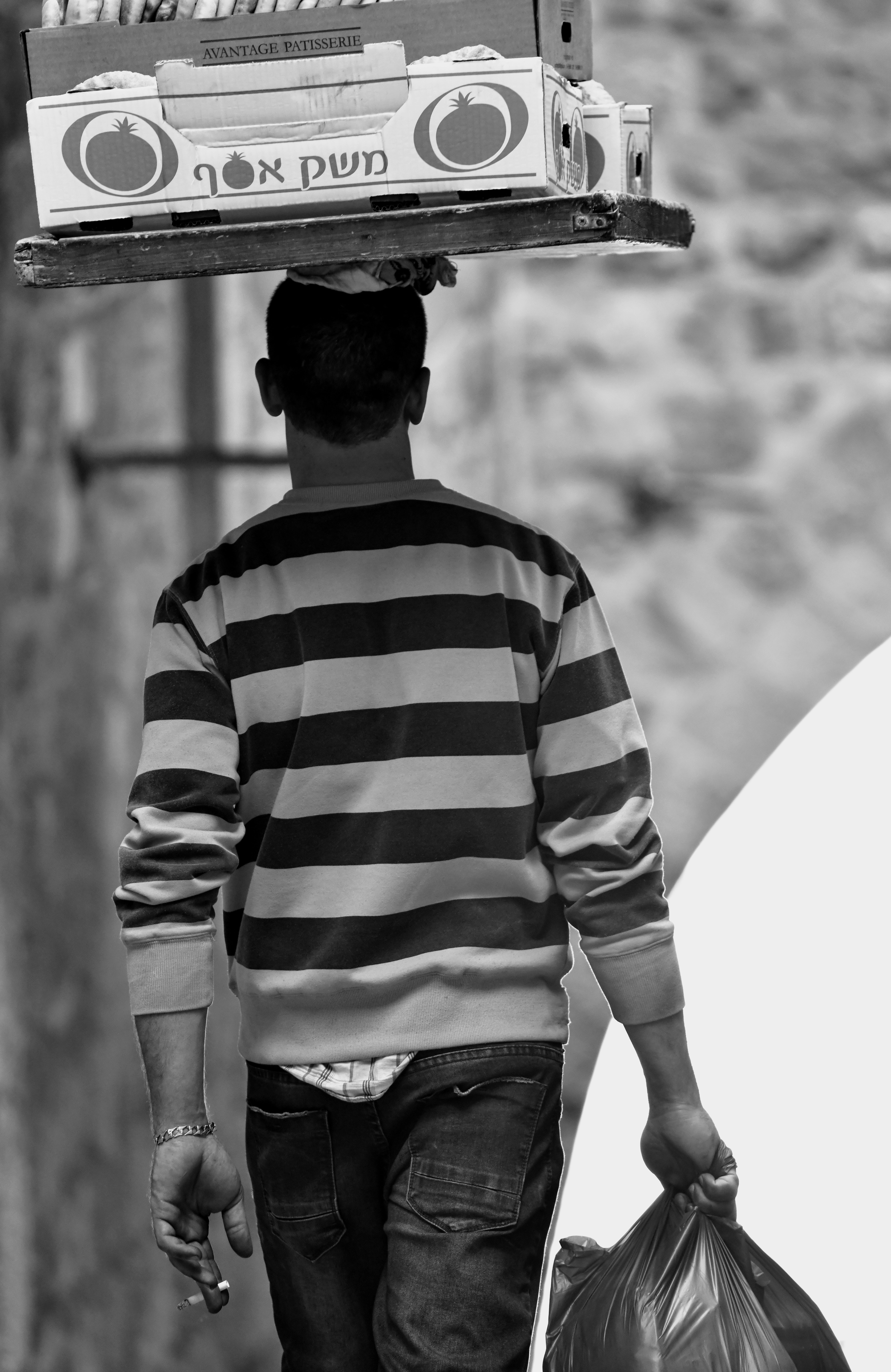 I captured this Arad worker walking in the street carrying a box on top of his head.