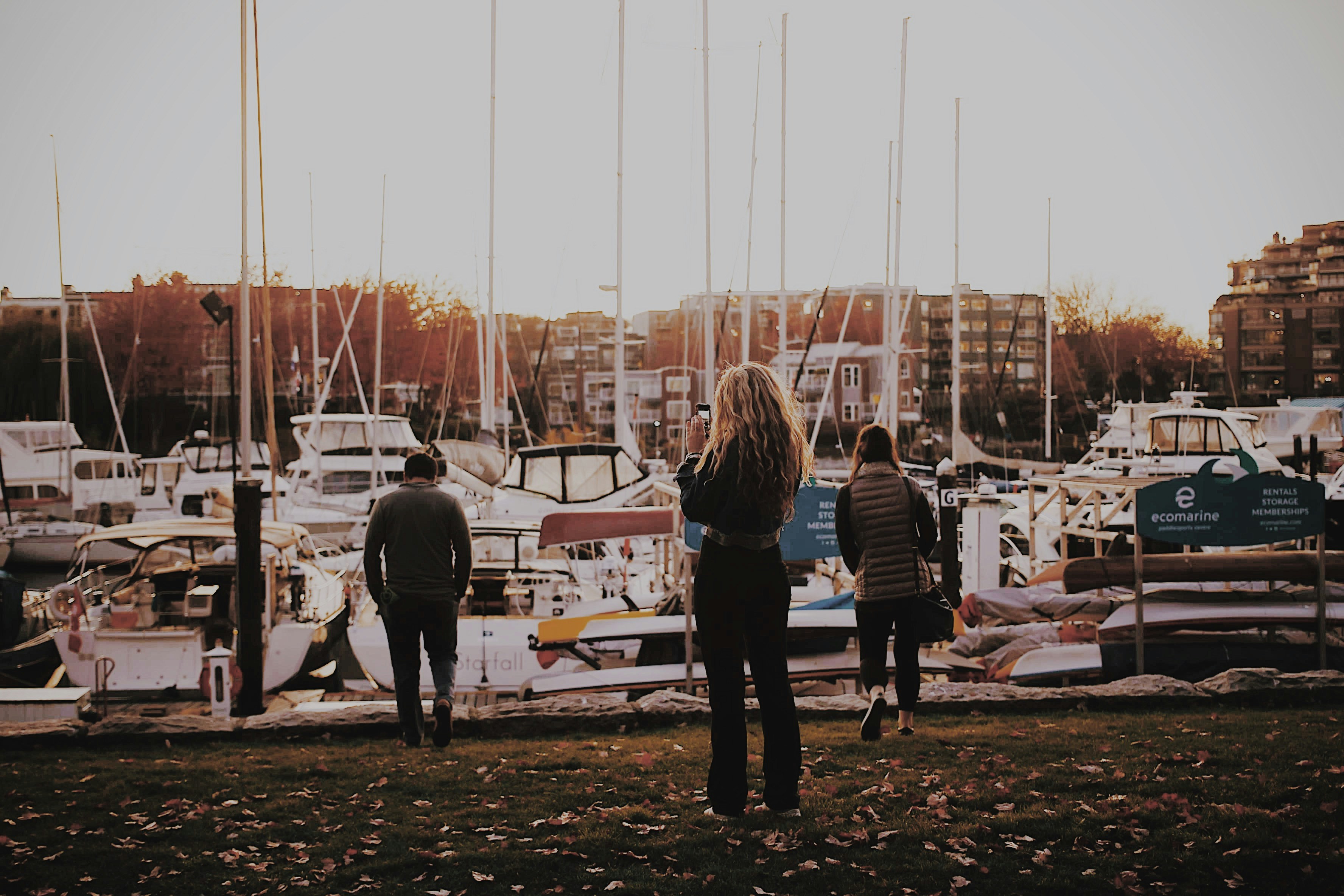 Dusk at the Marina: Three Figures Before a Sea of Sails