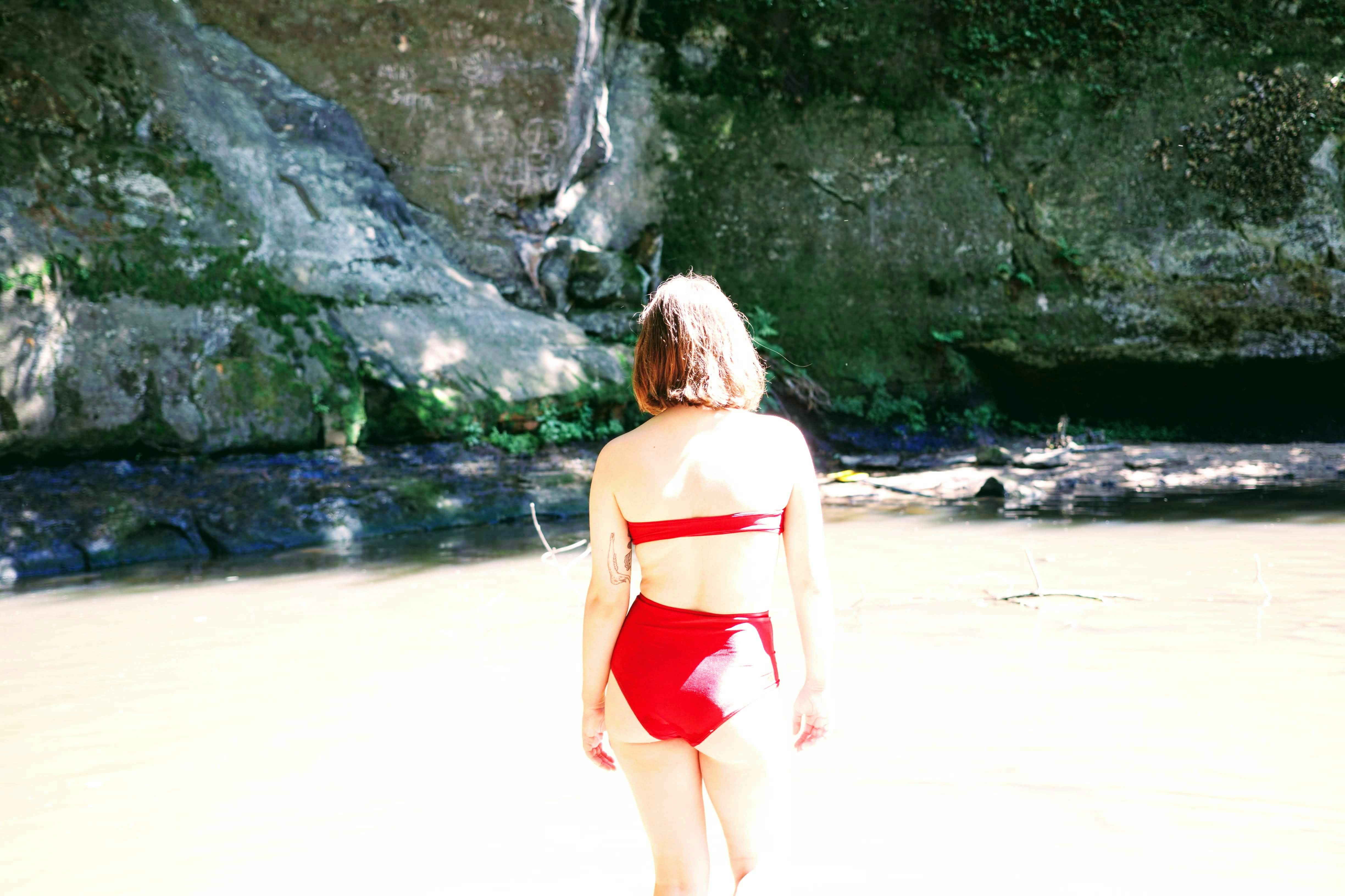 Crimson at the Edge: A Red Swimsuit in Sunlit Shorewater