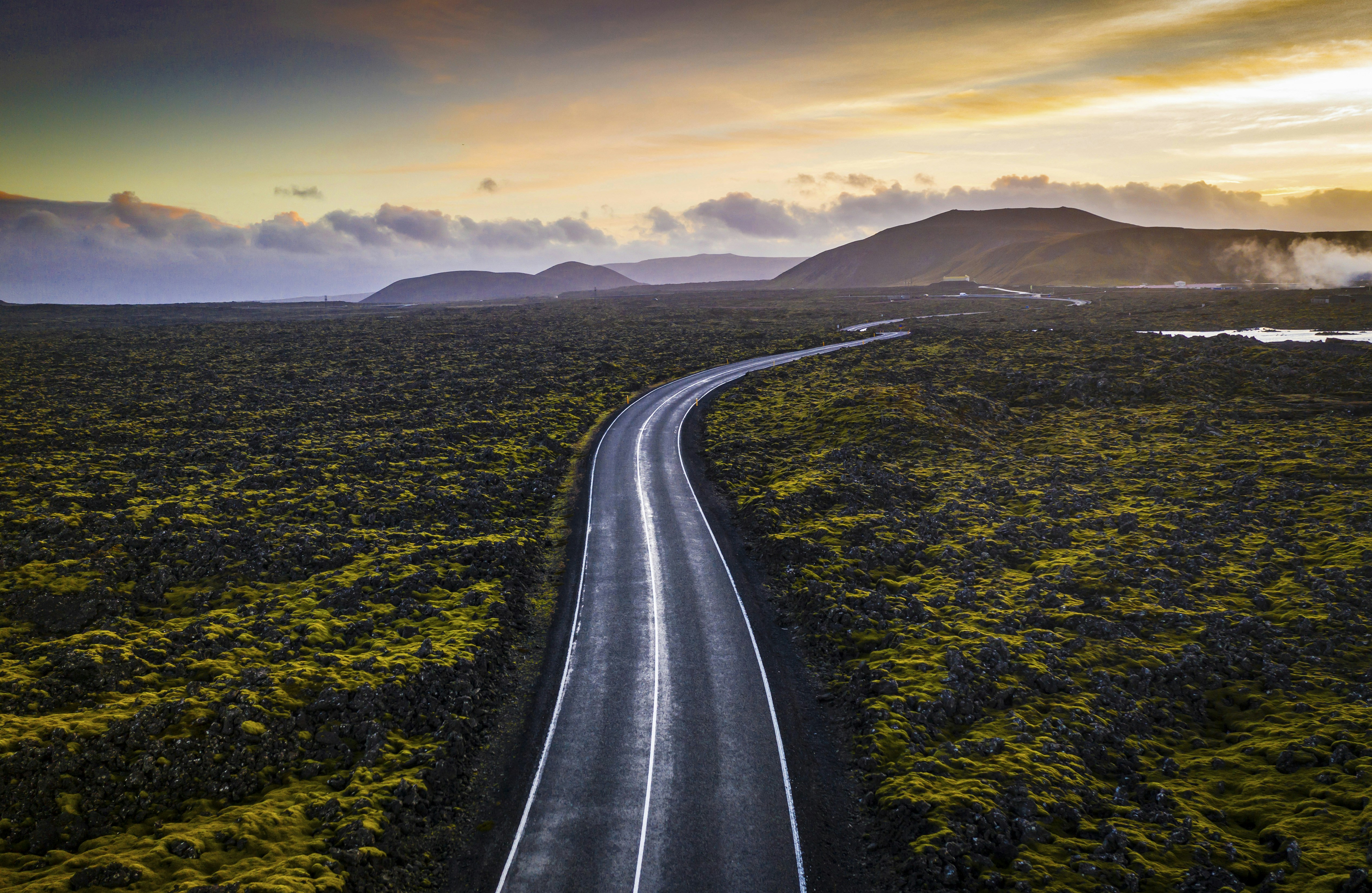 A road going through a green landscape photo – Free Grey Image on Unsplash