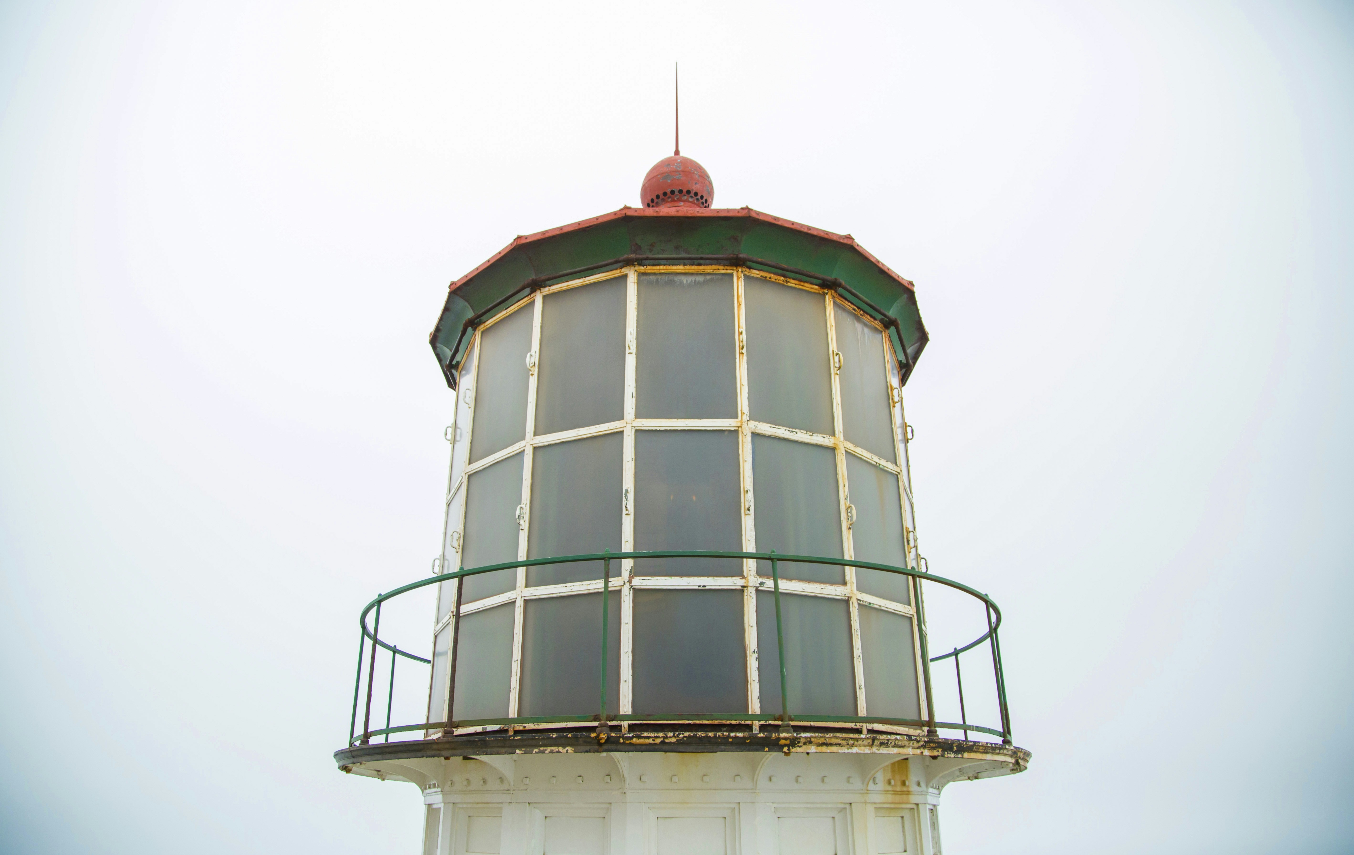 The Lantern Keeper: A Weathered Lighthouse Crowned by Glass and Rust