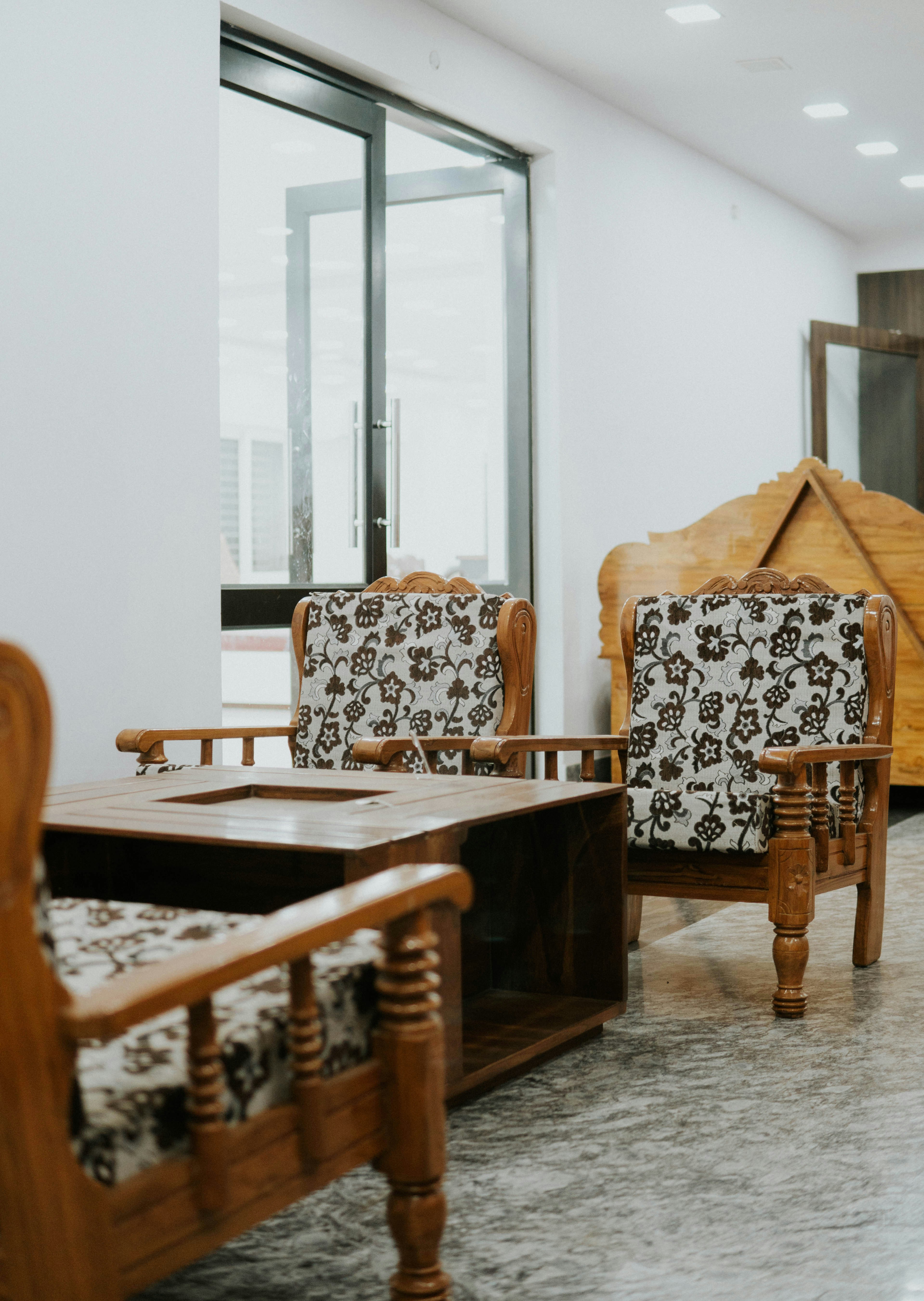 Sunlit Lounge: Ornate Woodwork and Floral Upholstery in a Quiet Corner